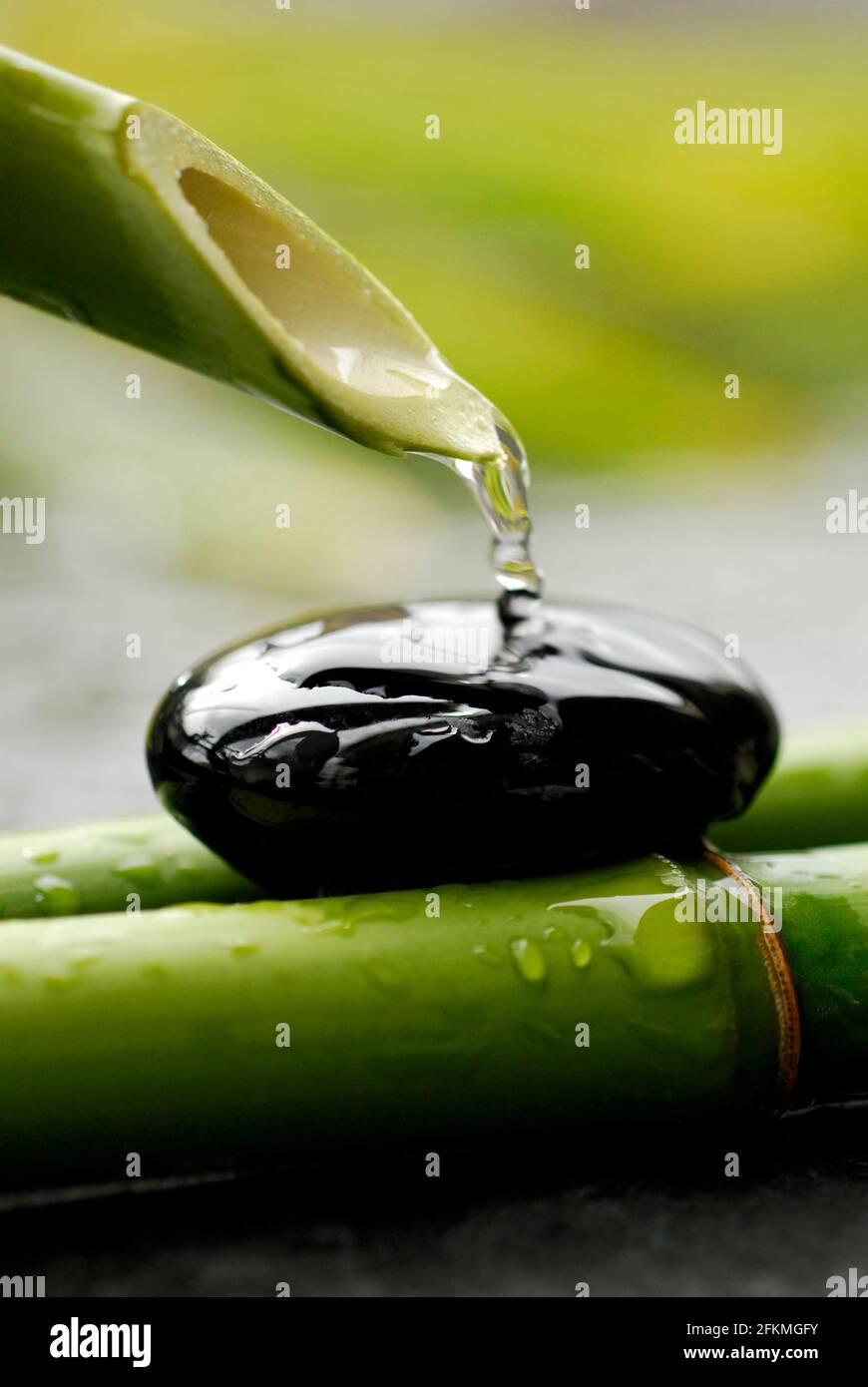 Water flows from bamboo cane, stone Stock Photo - Alamy