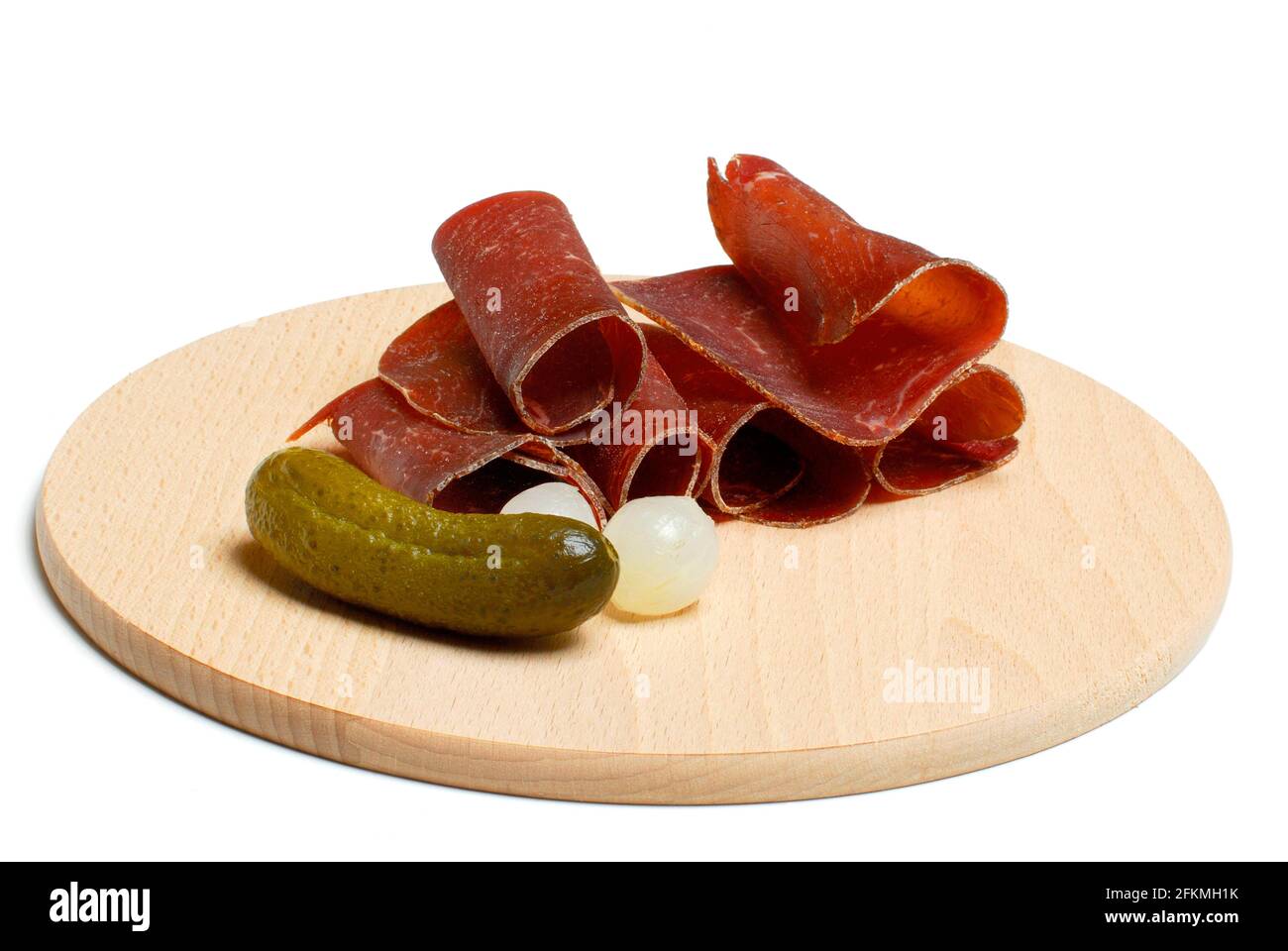 Buendner dried meat on wooden board, with delicacy gherkin and silver ...