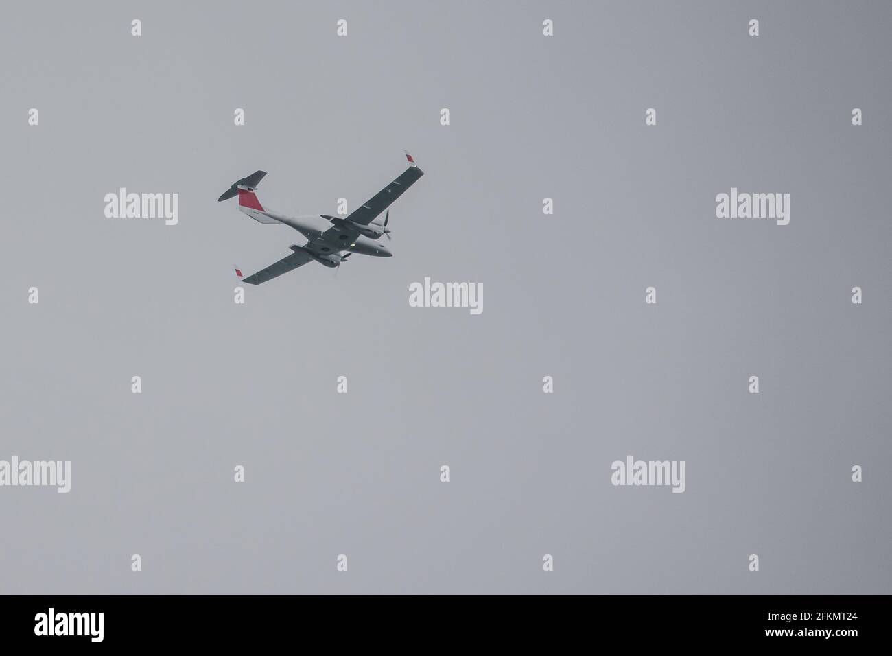 a small modern propeller plane flies in the gray sky Stock Photo - Alamy