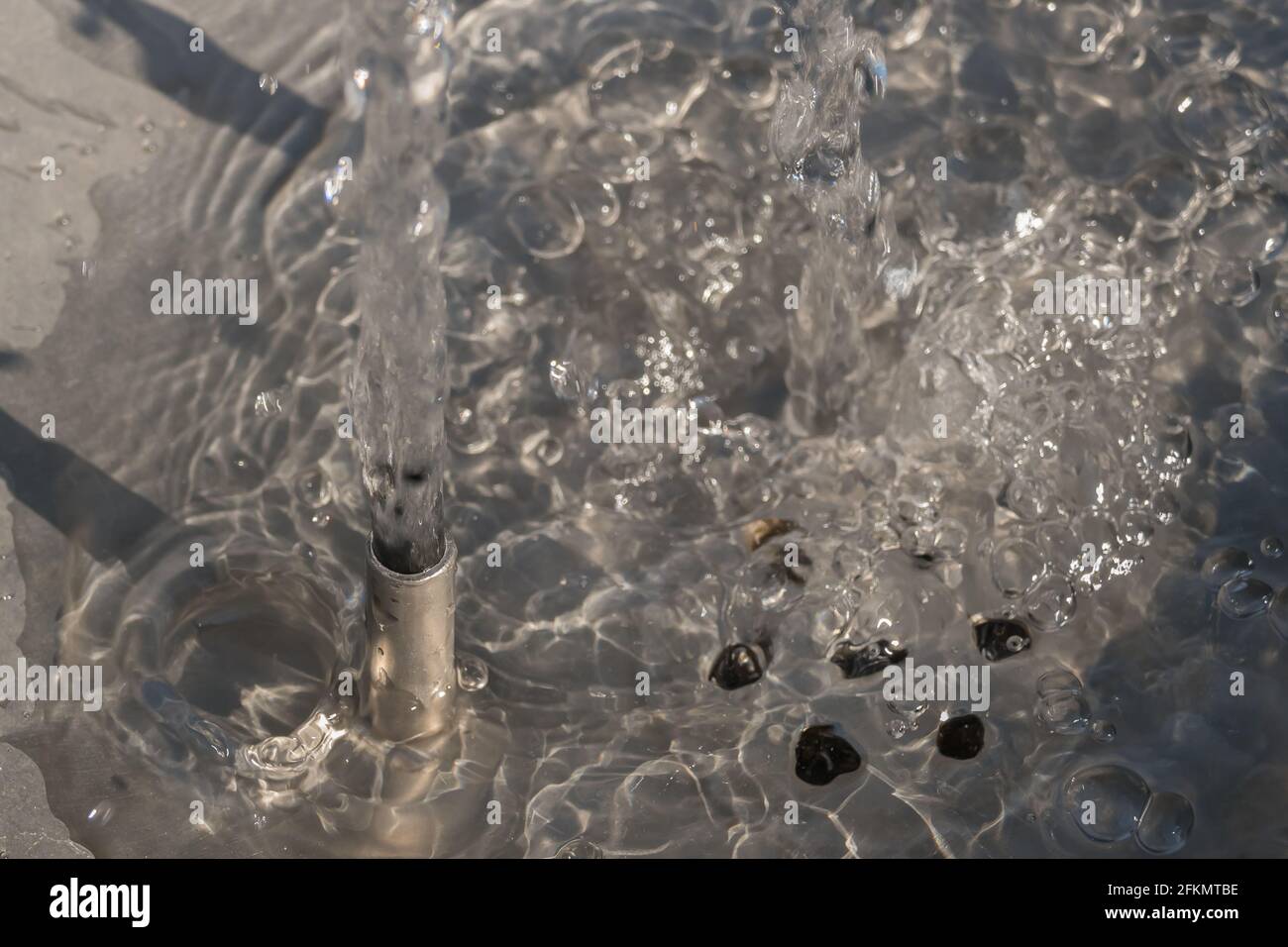 detail of a stainless steel fountain tap with a vertical jet of water ...