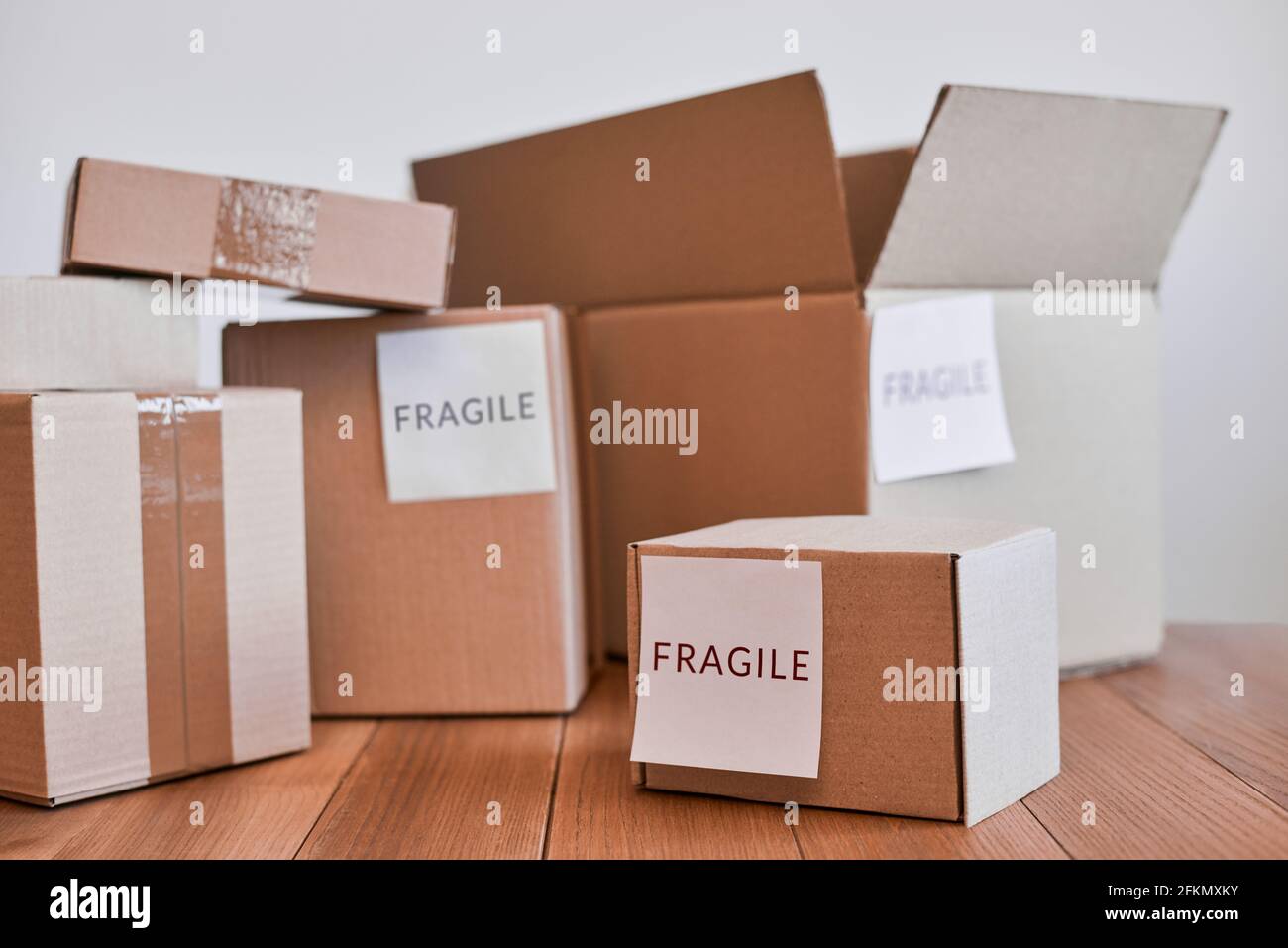 Various cardboard boxes with fragile label on wooden table Stock Photo ...