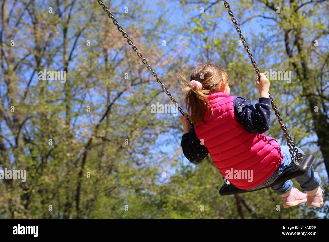 Girl swinging on a playground (model released Stock Photo - Alamy