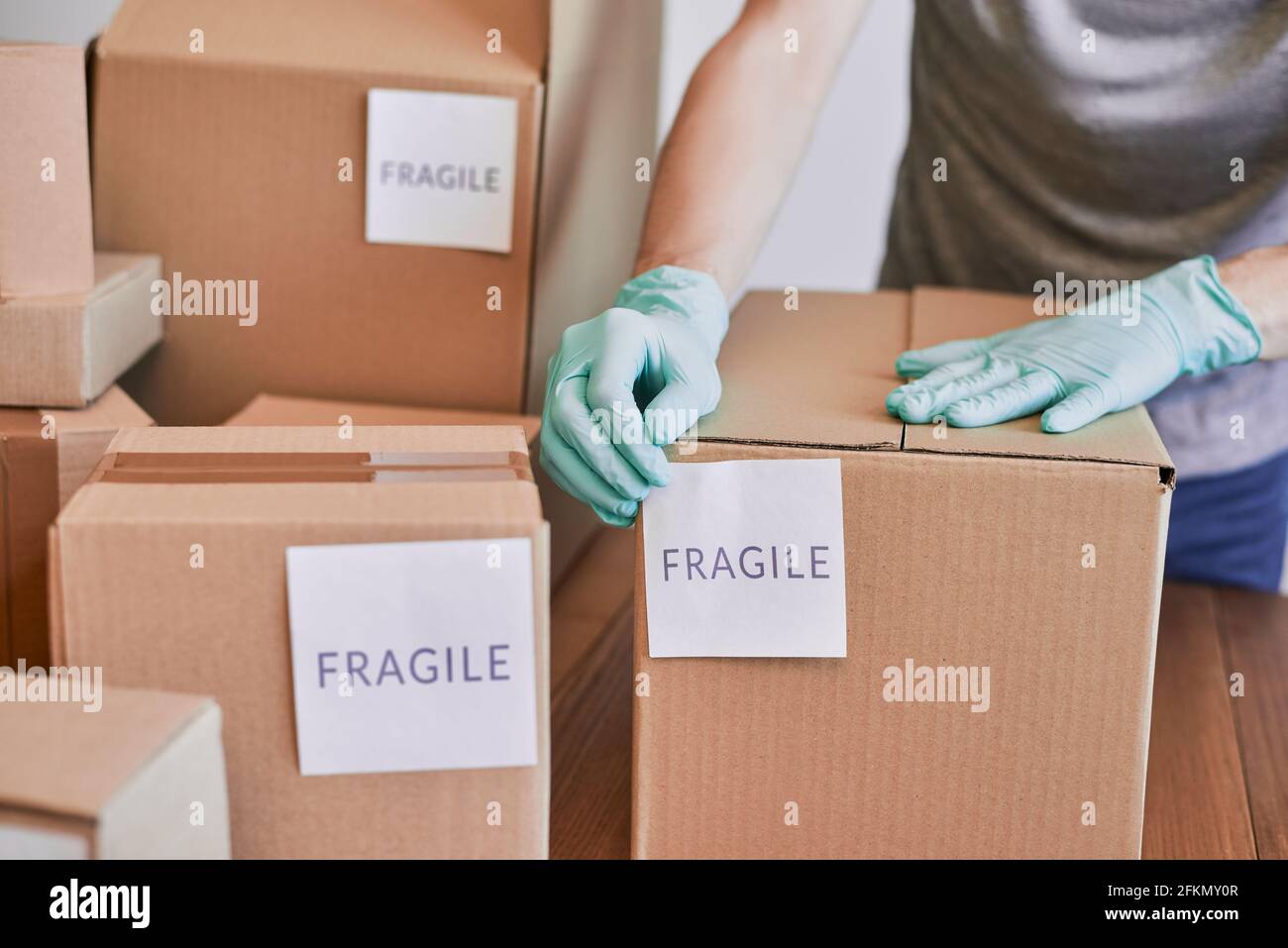 Postal worker putting a fragile label on a cardboard box Stock Photo ...