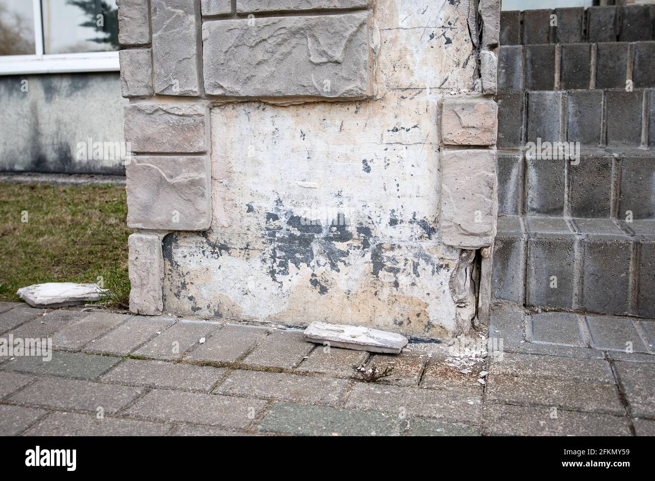 Facade of a public building. Stone finishing tiles. Aging, poor quality ...