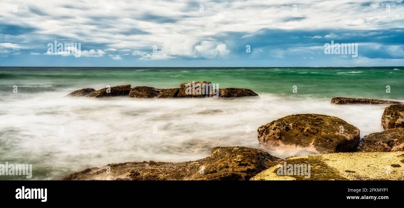 Green sea and smooth rocks Stock Photo - Alamy