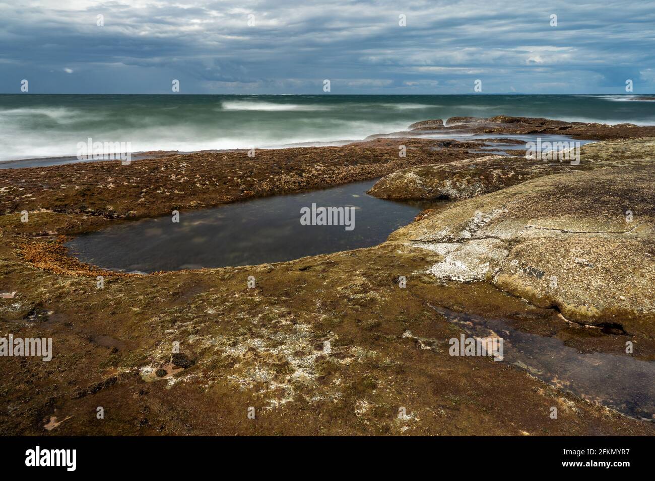 Rock pool with sea and sky in background Stock Photo - Alamy