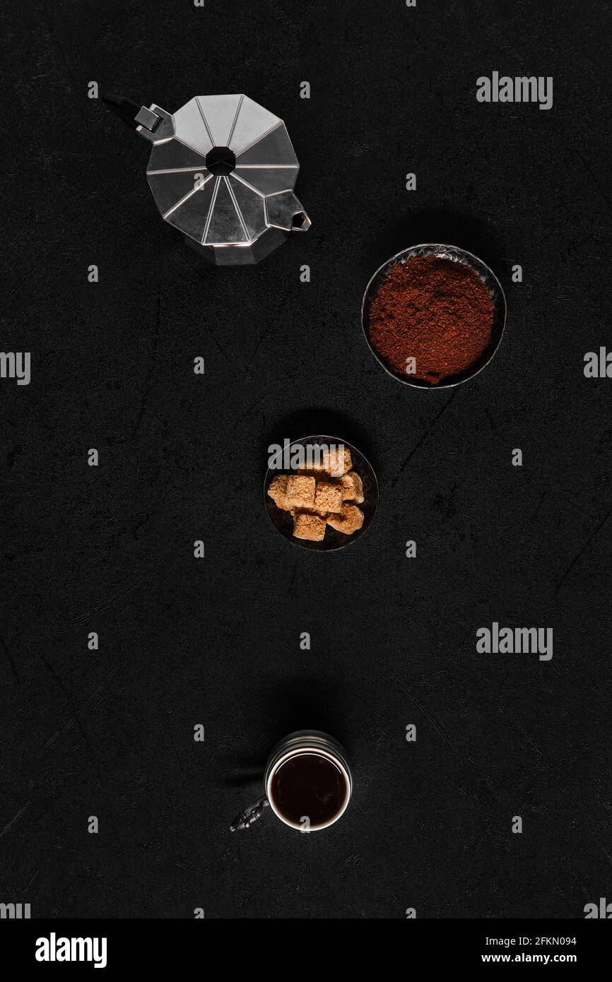 Overhead view of cup with espresso coffee, ground coffe and broun sugar ...