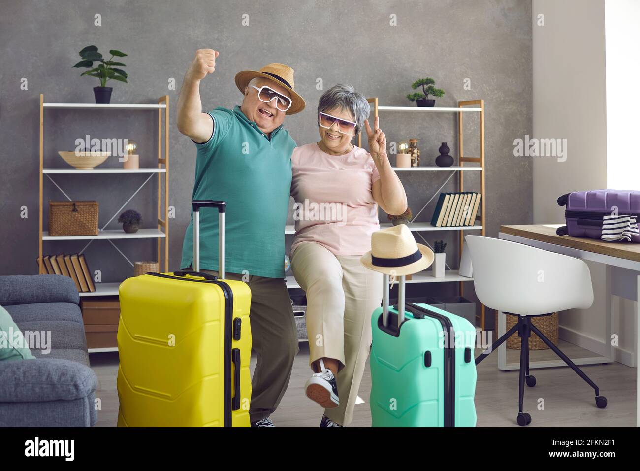 Happy active senior couple having fun at home before going on holiday ...