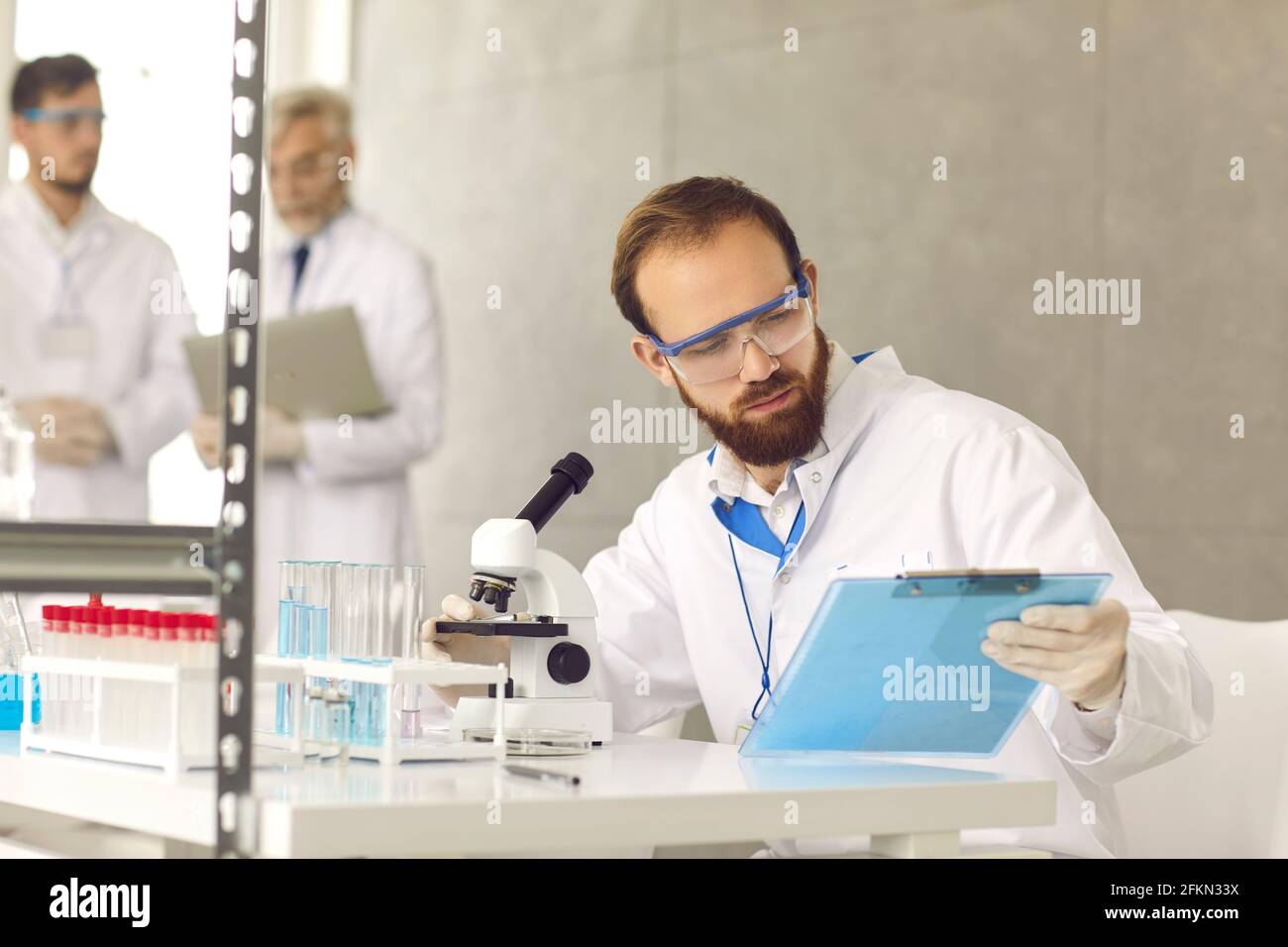 Portrait of scientist looking at clipboard with test result work at ...
