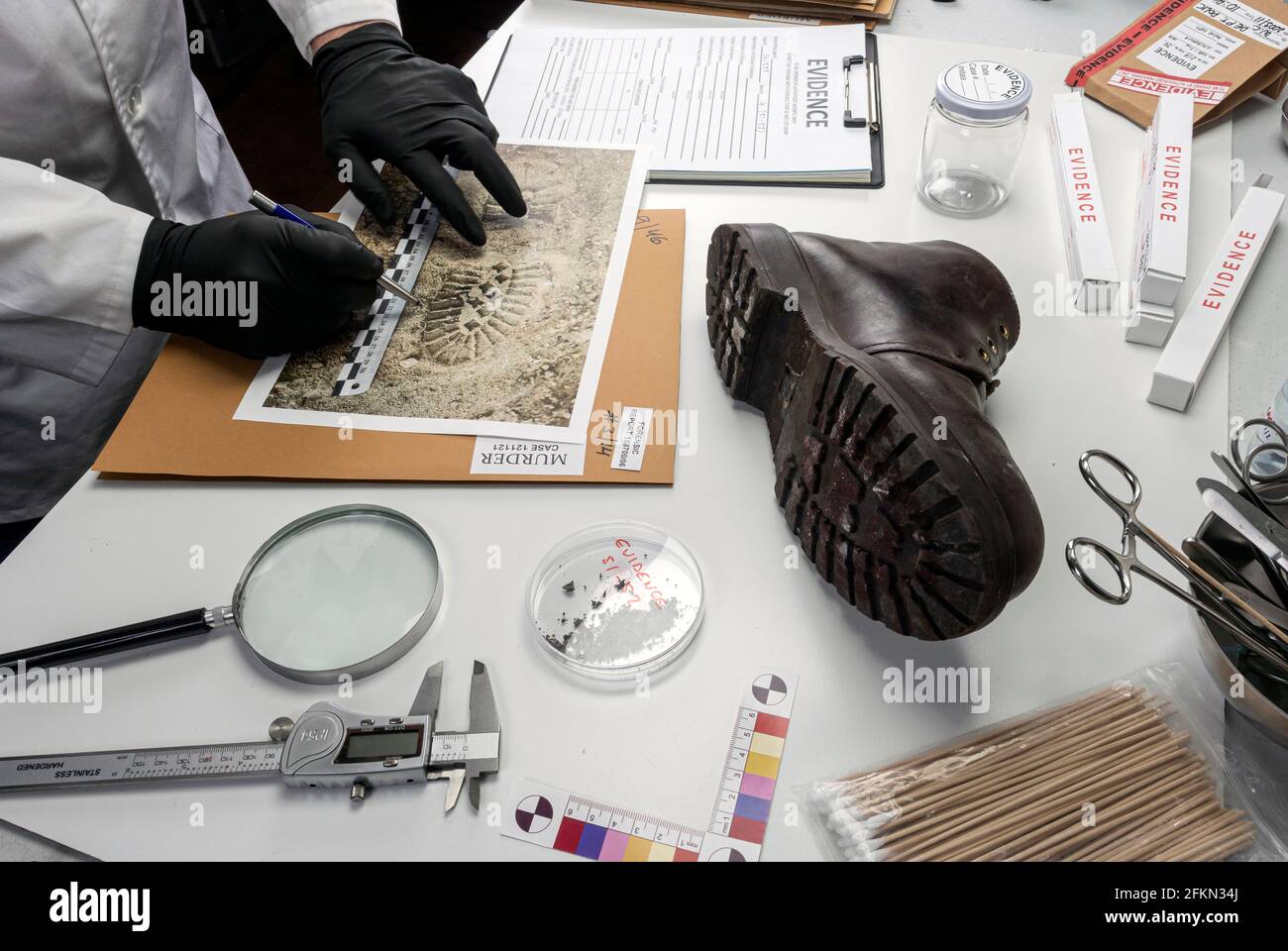 Police scientist investigates a shoe sole tape tread involved in crime ...