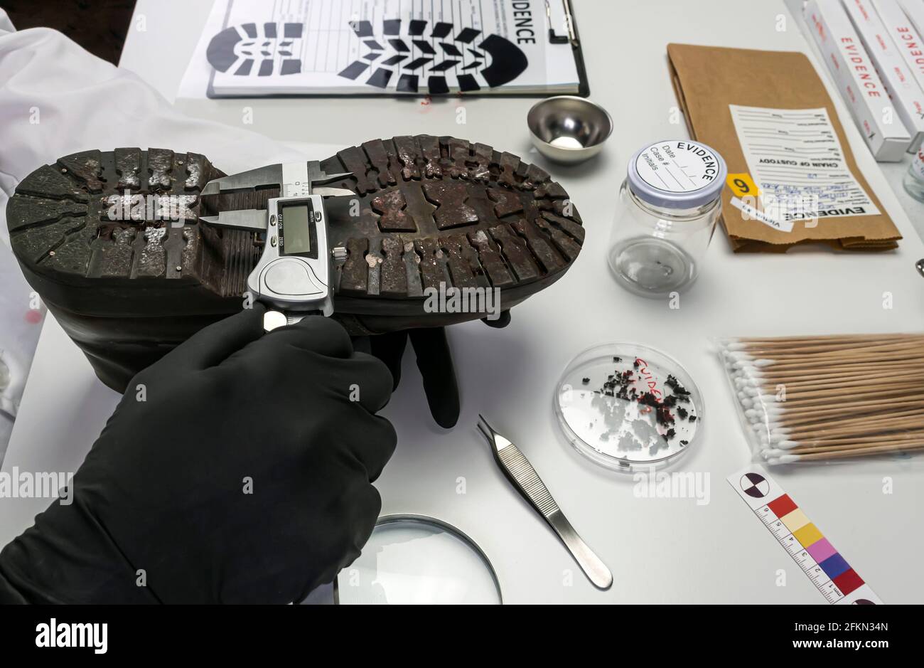Police scientist investigates with a scale on a shoe sole tape tread ...