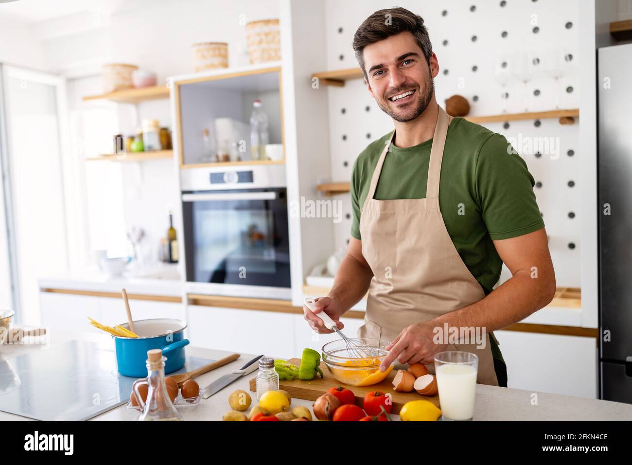 Happy caucasian man cooking in kitchen at home, smiling Stock Photo - Alamy