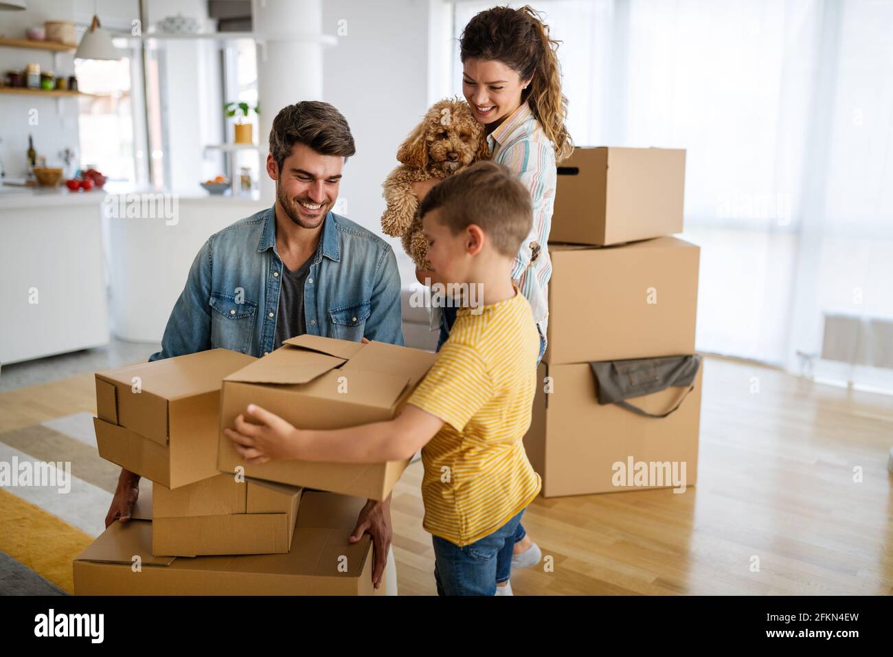 Family unpacking cardboard boxes at new home Stock Photo - Alamy