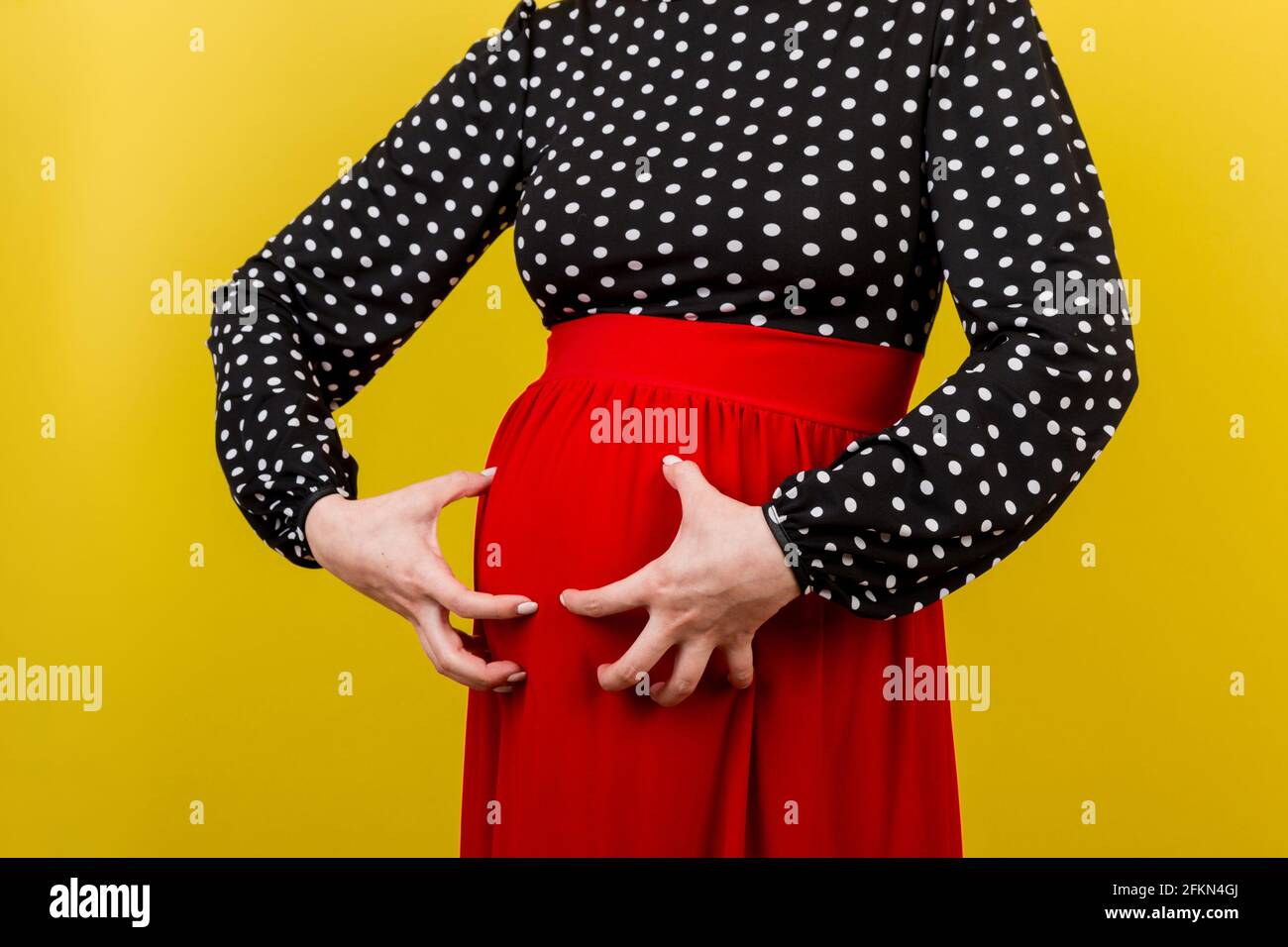 Pregnant woman scratching her belly on colored background Stock Photo ...