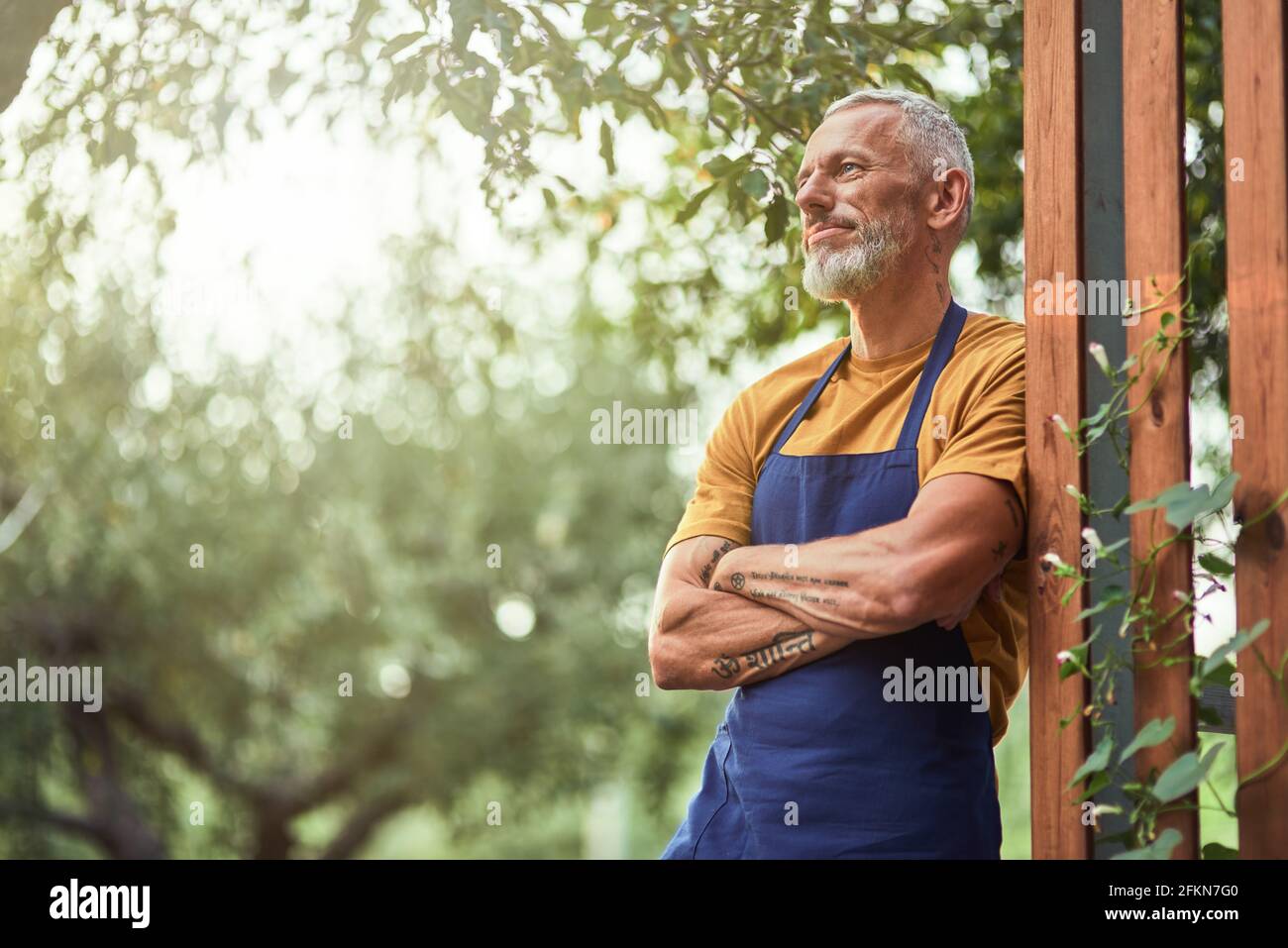 Middle aged caucasian farmer standing near fence Stock Photo - Alamy