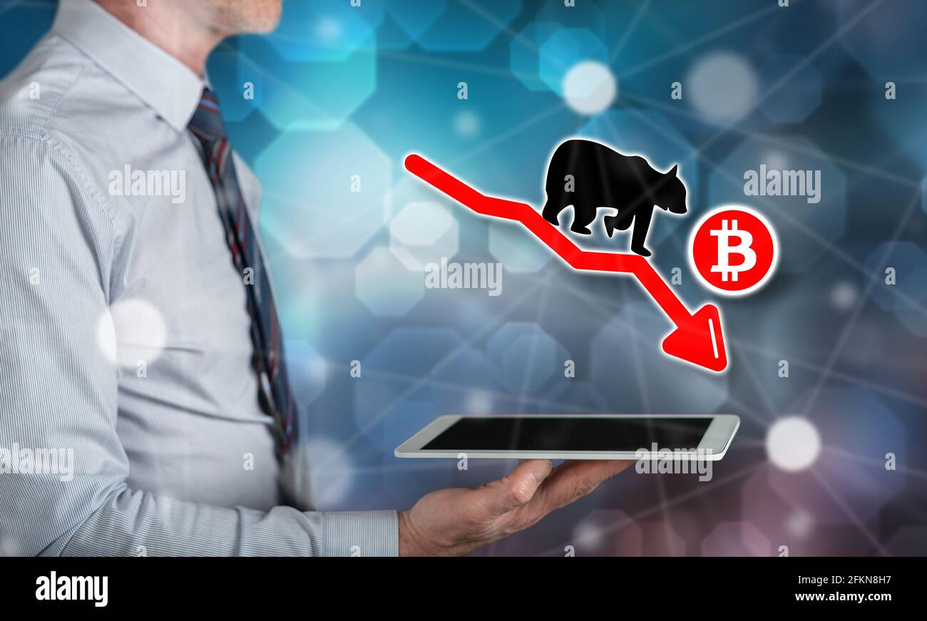 Bitcoin bearish trend concept above a tablet held by a man Stock Photo ...