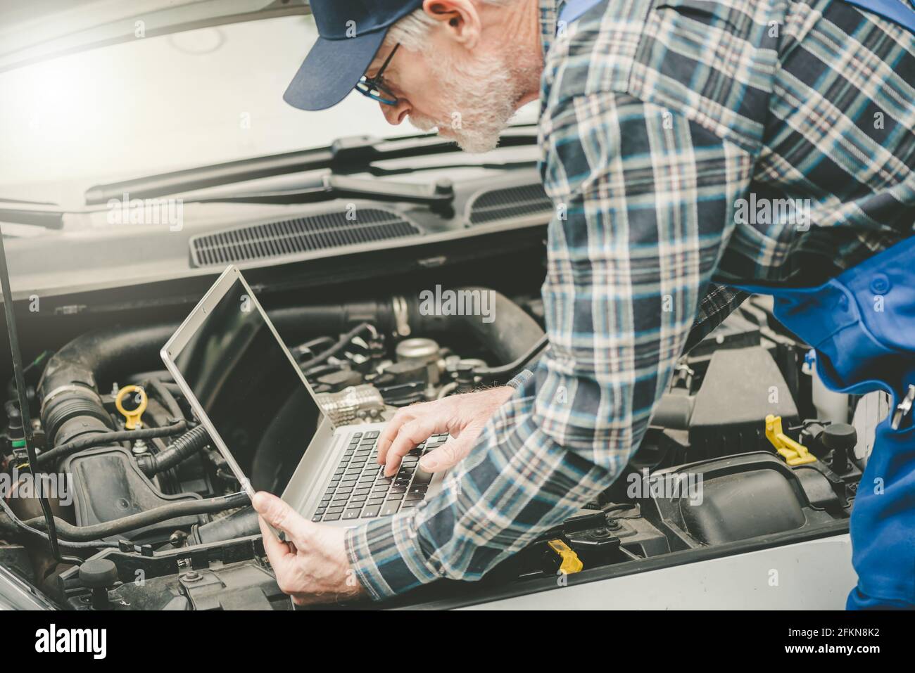 Car mechanic using laptop for checking car engine Stock Photo - Alamy
