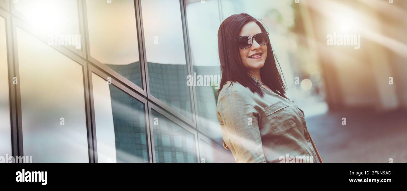 Portrait of happy pretty young brunette outdoors, light effect ...