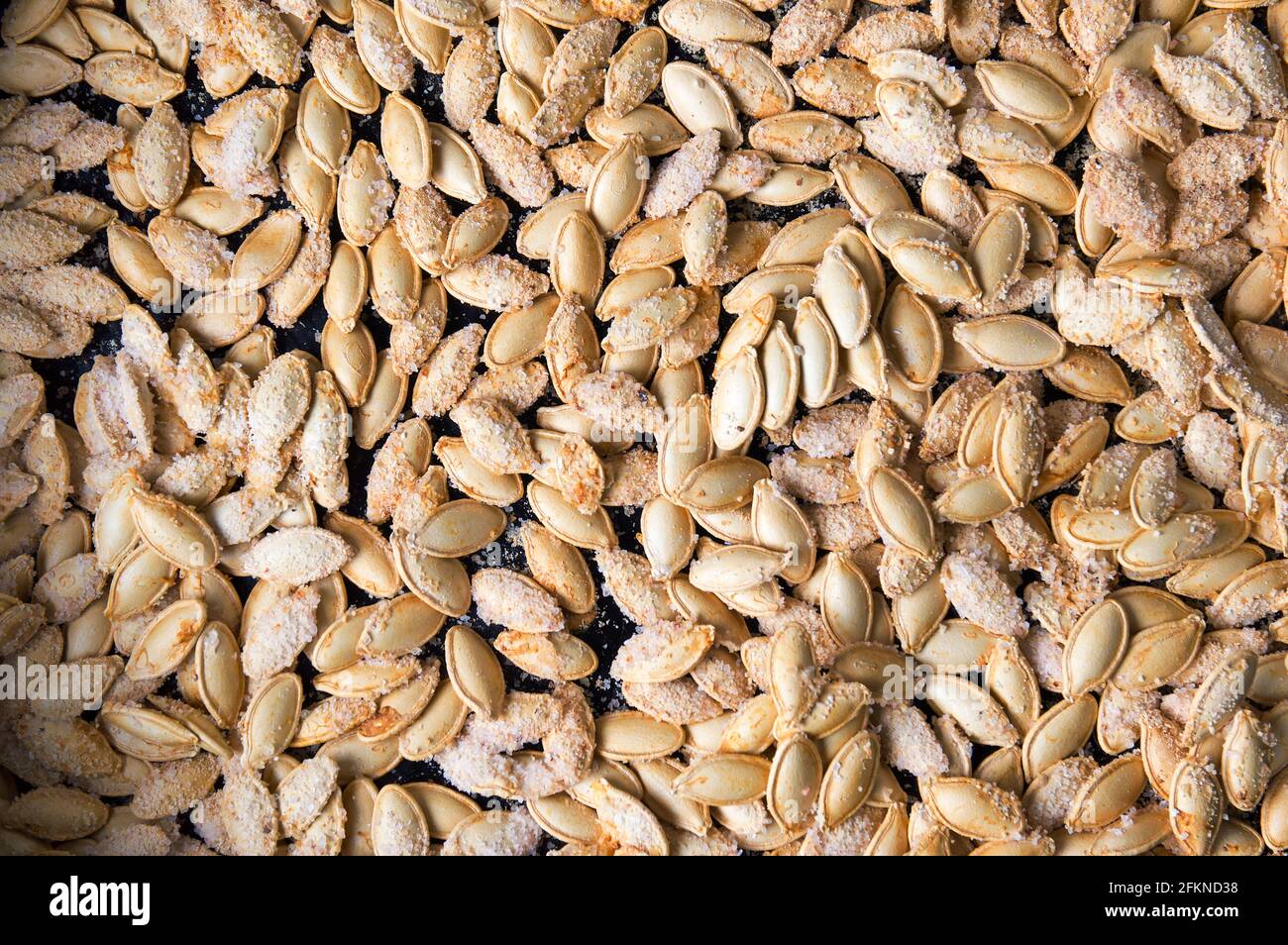 Baked pumpkin seeds covered with salt background Stock Photo - Alamy