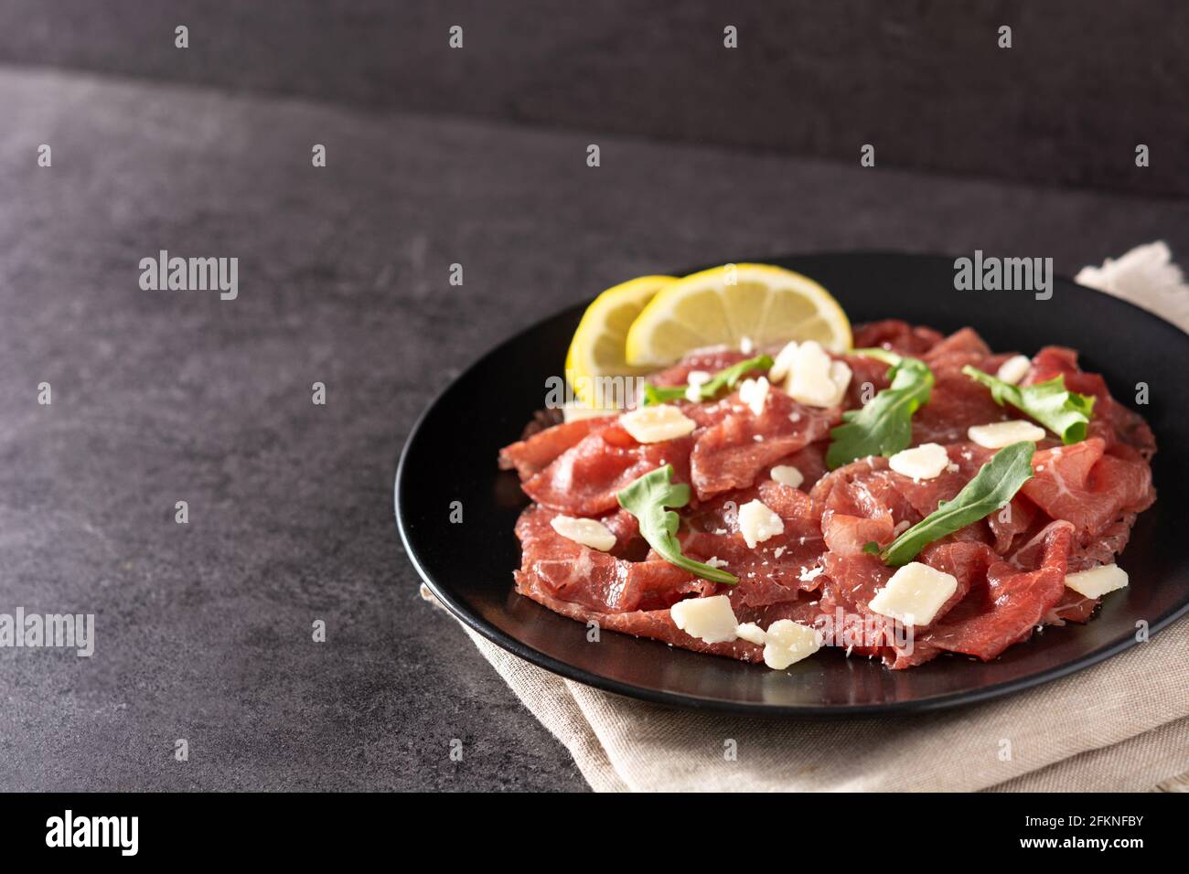 Marbled beef carpaccio on black slate background Stock Photo - Alamy