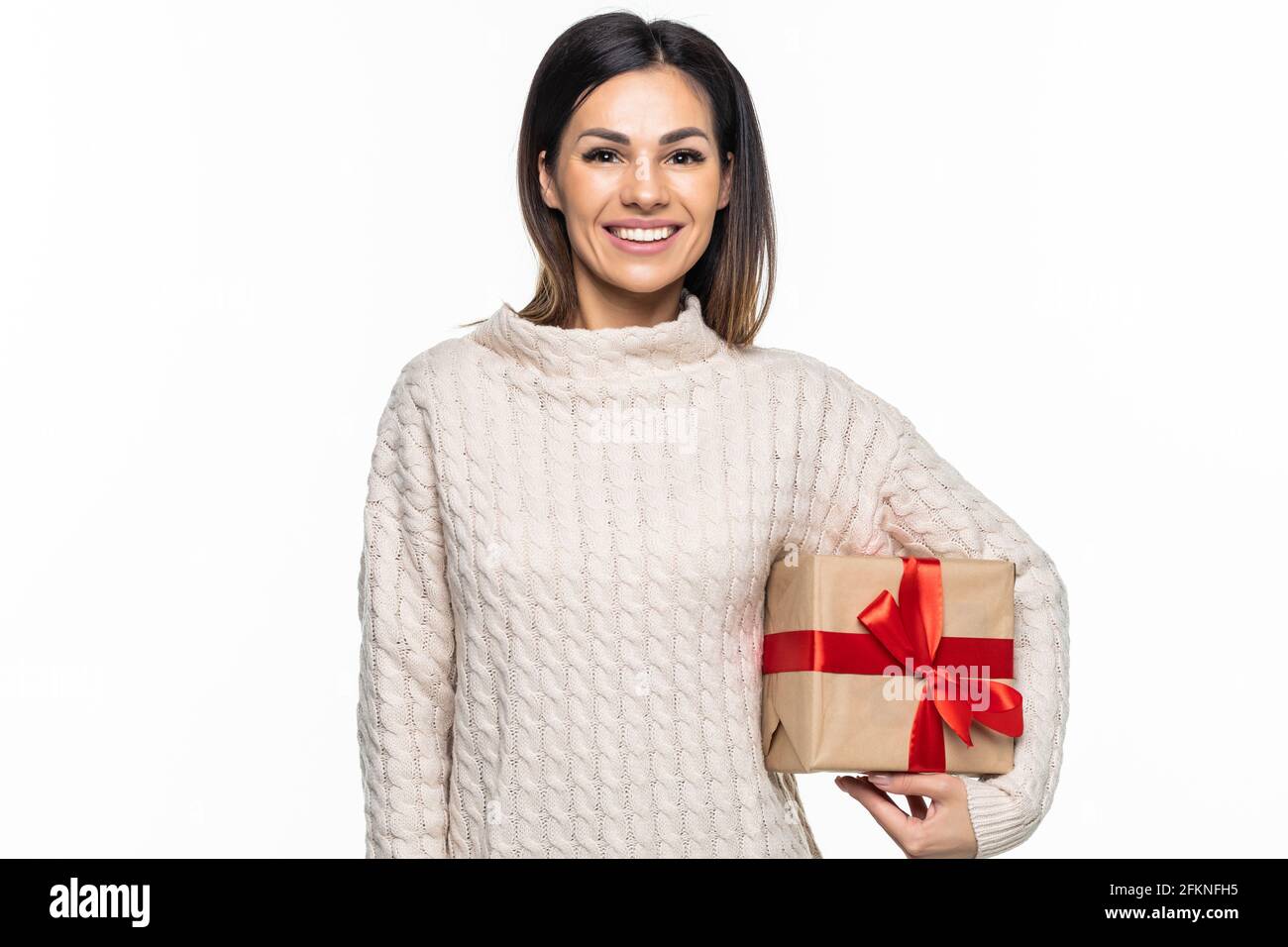 Portrait of a happy woman holding present box while standing isolated ...