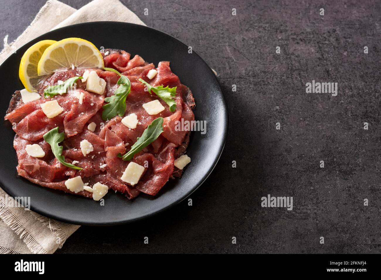 Marbled beef carpaccio on black slate background Stock Photo - Alamy