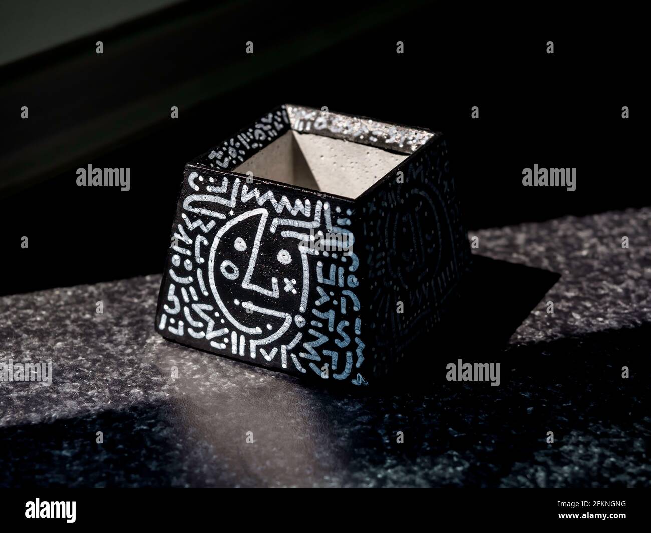 DIY black concrete pot, pyramid shape with art drawing on dark ...