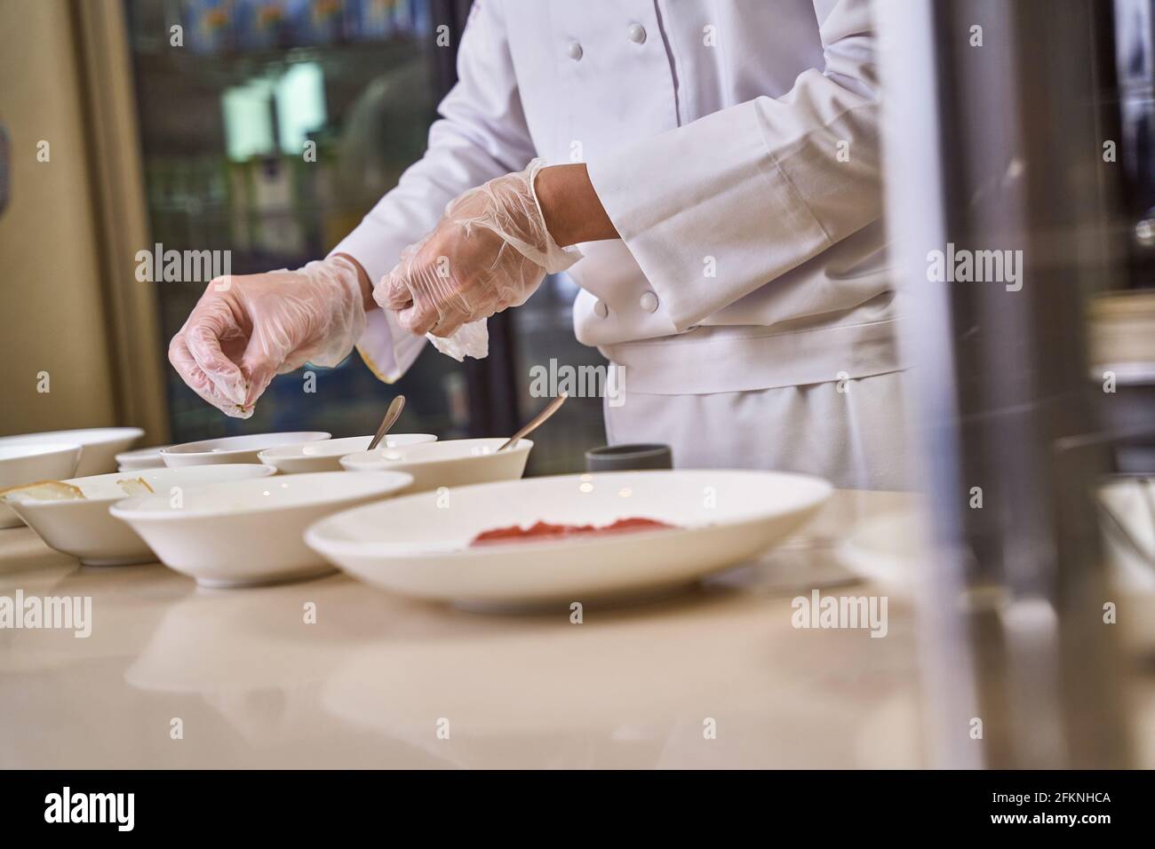 Chef adding spices to dishes in many bowls Stock Photo - Alamy