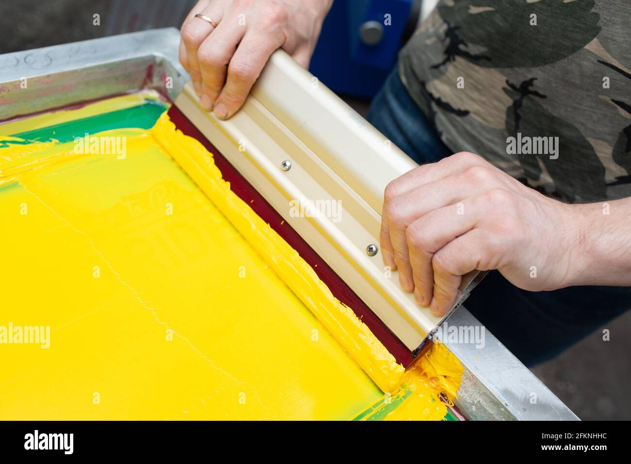 Serigraphy silk screen print process at clothes factory. Frame ...