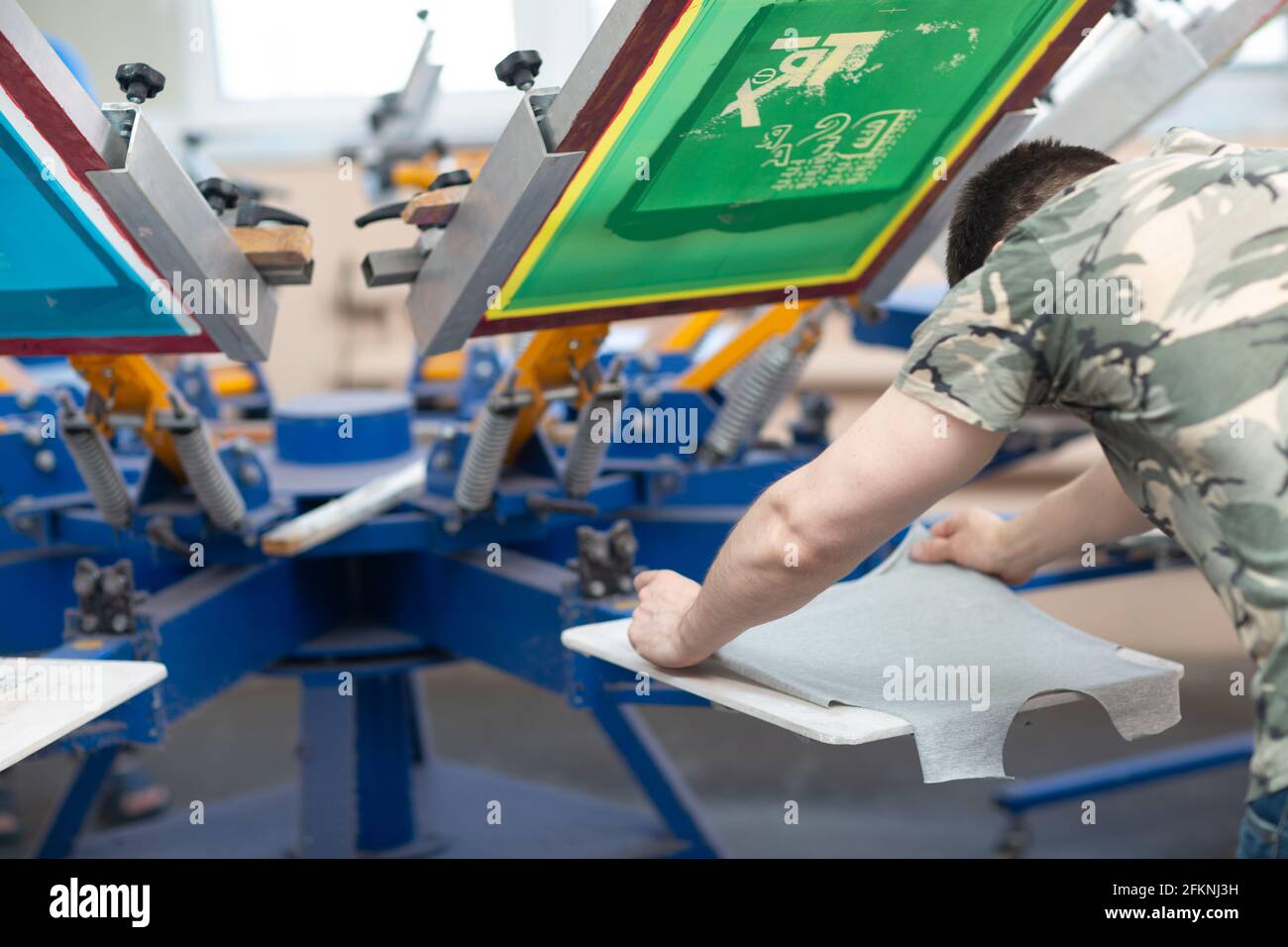 Serigraphy silk screen print process at clothes factory. Frame ...