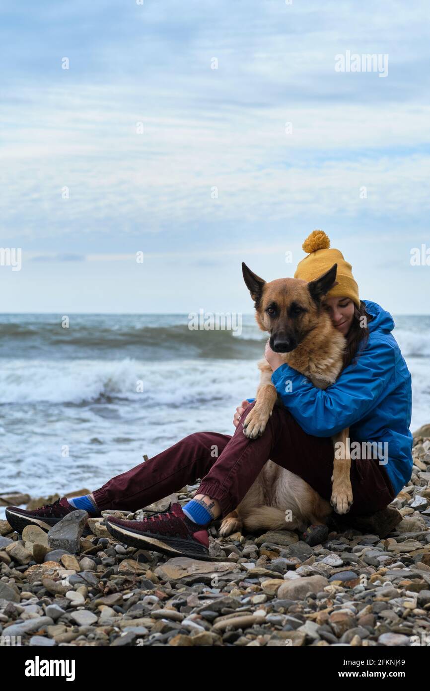 Hug the sheepdog tightly with both hands. Young cute Caucasian woman ...