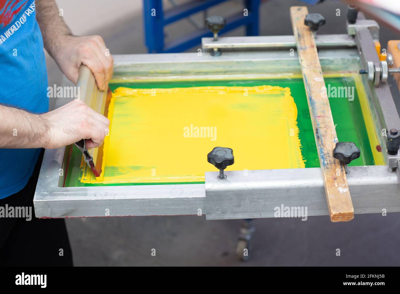 Serigraphy silk screen print process at clothes factory. Frame ...