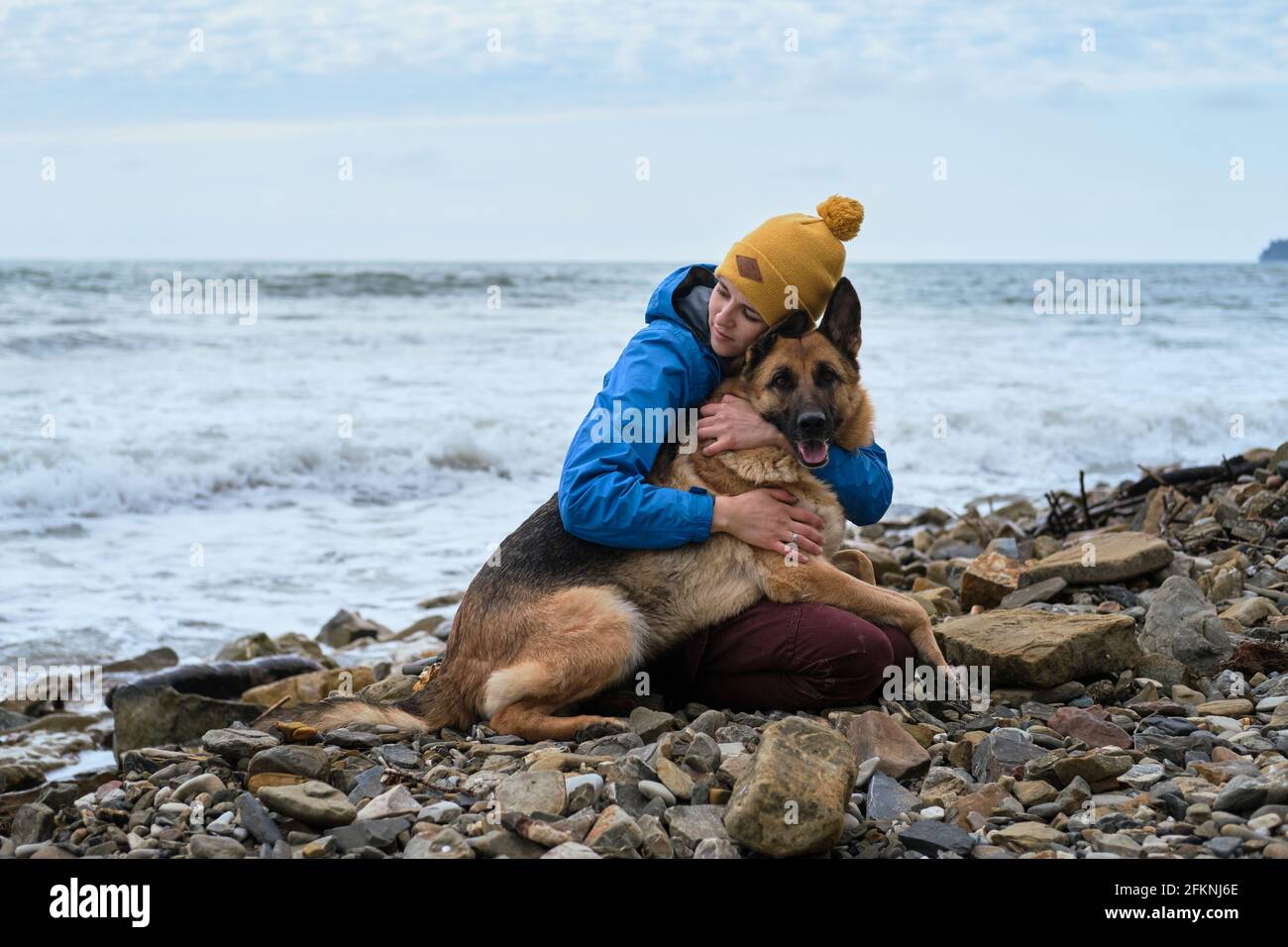 Hug the sheepdog tightly with both hands. Young cute Caucasian woman ...