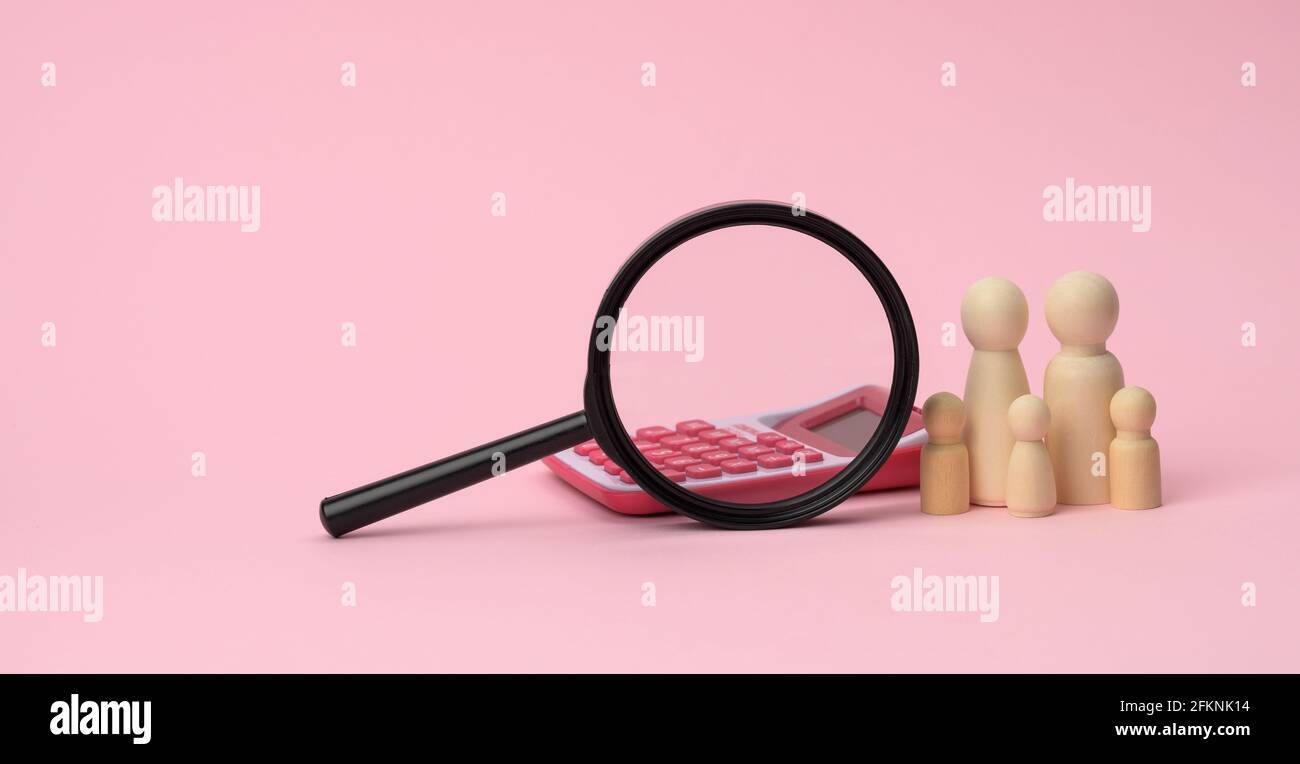 wooden figurines of little men family, magnifier and calculator on a ...