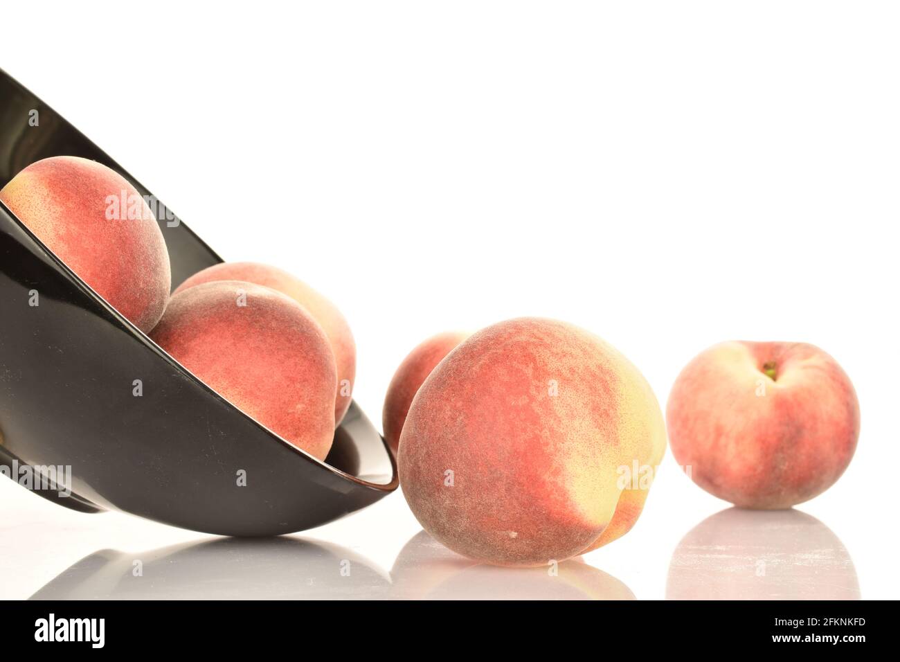 Several ripe sweet, natural peaches with a black plate, close-up ...