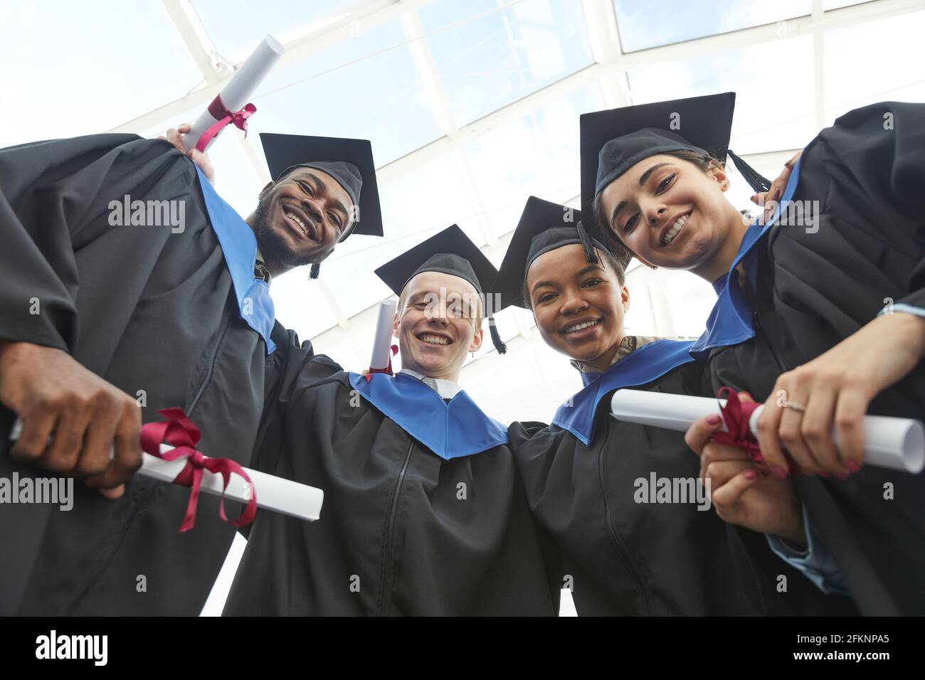 Low angle view at diverse group of happy young people wearing ...