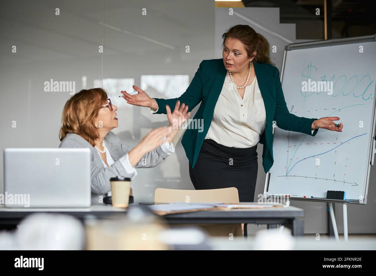 Woman and her supervisor having a heated discussion near chart Stock ...