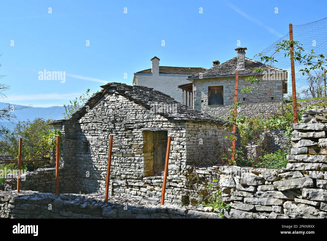 Old rural stone houses with a slate rooftop and chimneys in Koukouli, a ...