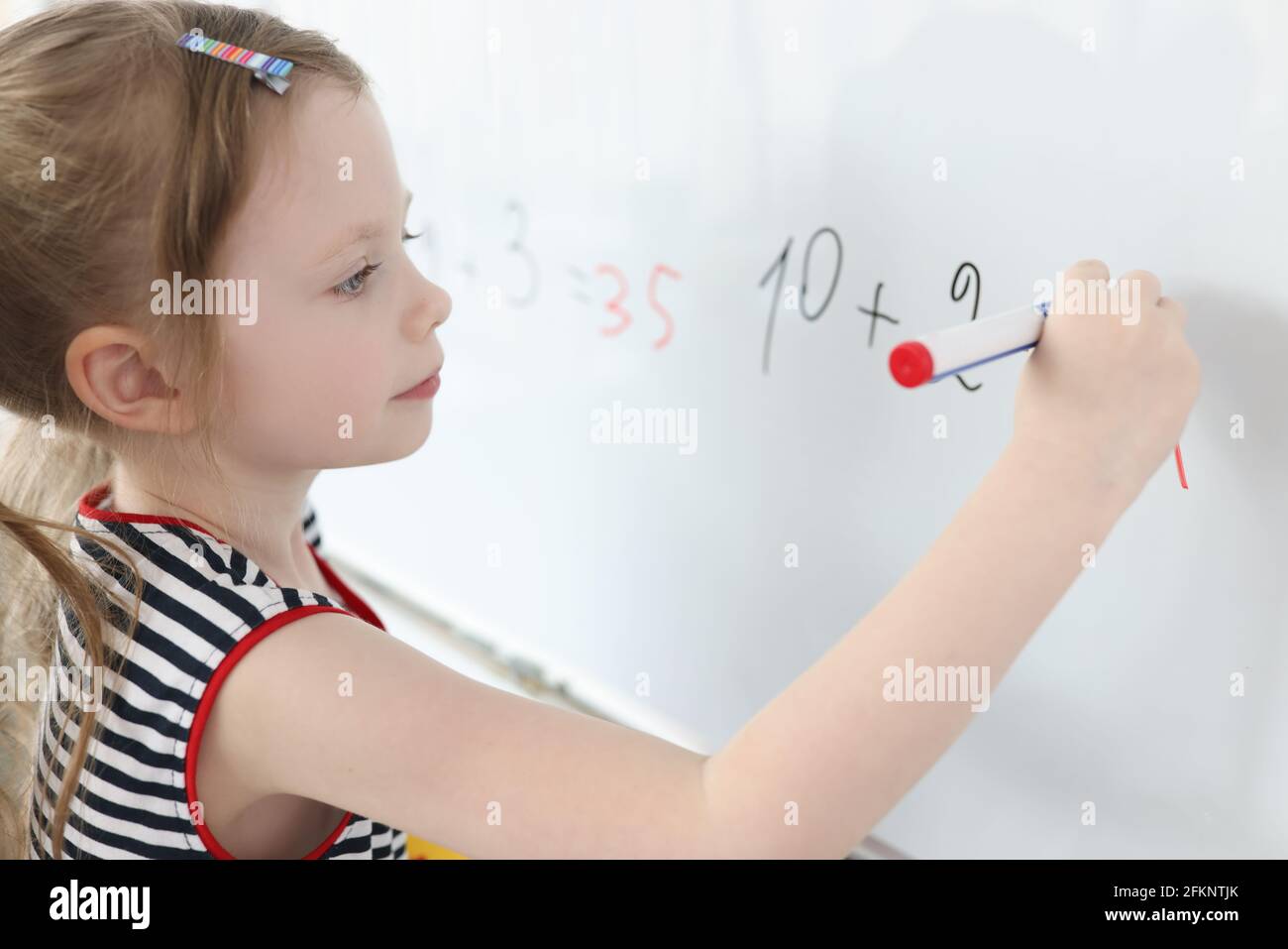 Little girl solving math examples on blackboard Stock Photo - Alamy