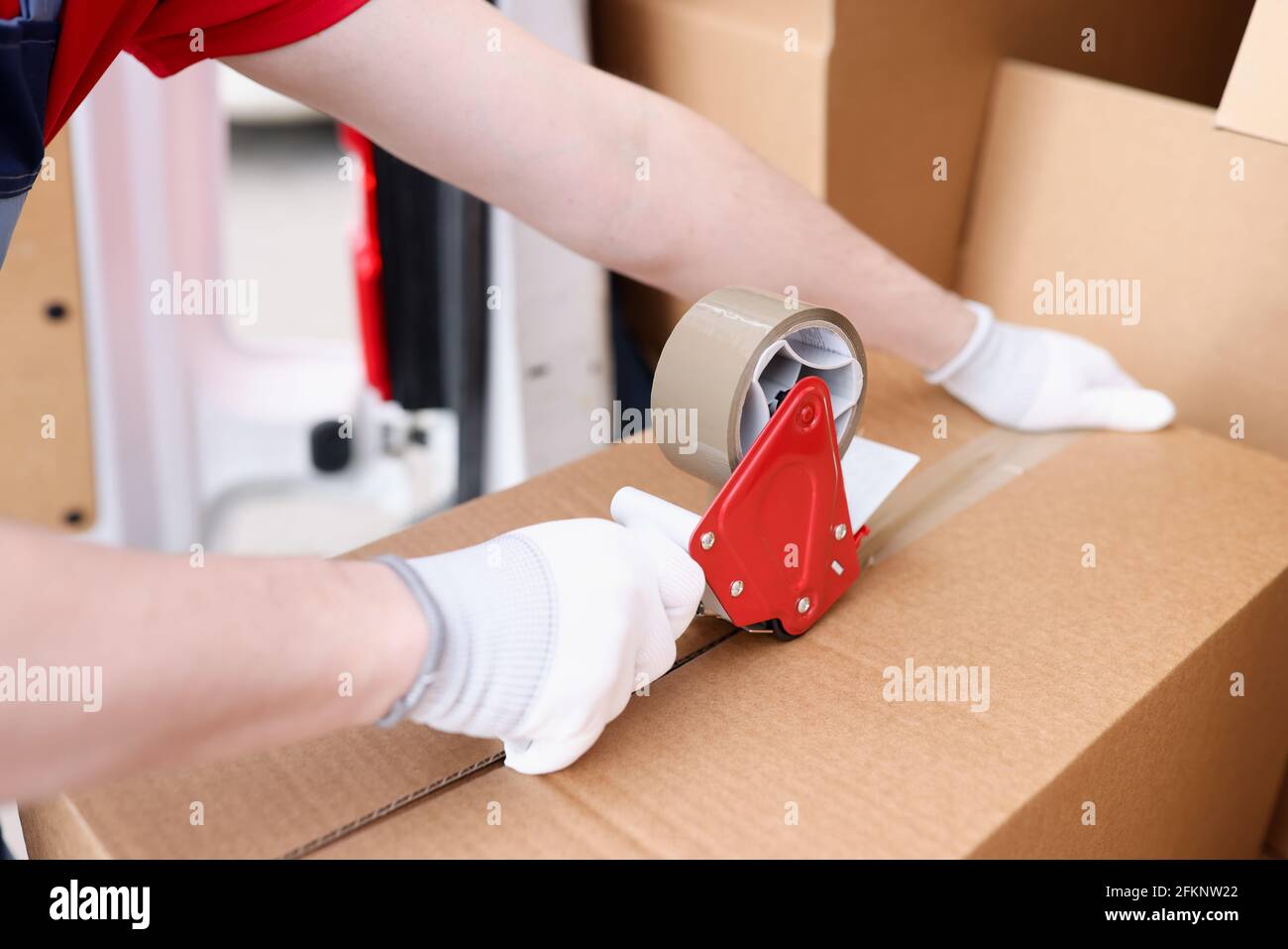 Man packing cardboard box using dispenser scotch tape closeup Stock ...