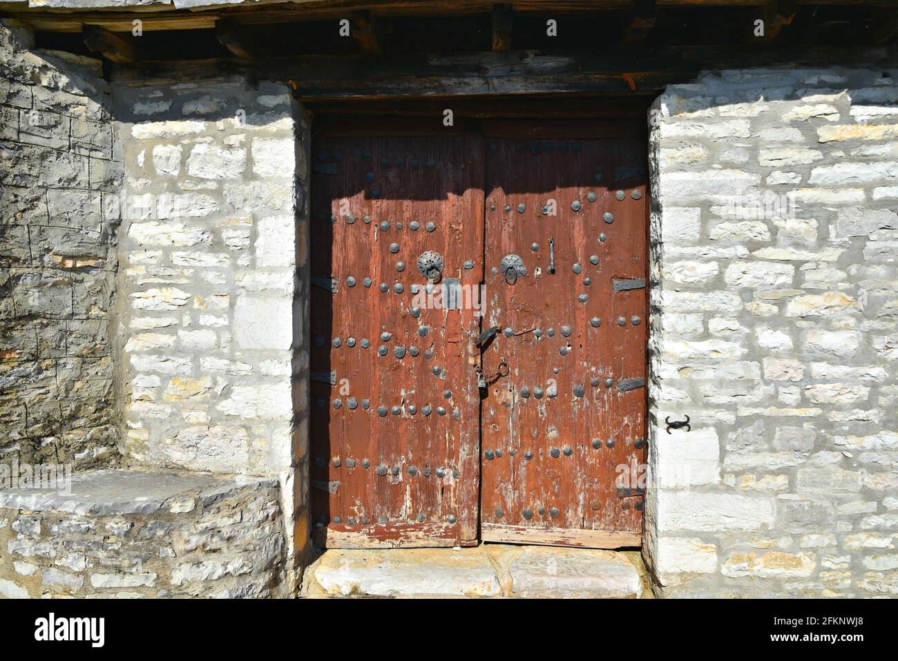 Rural stone house facade with a antique wooden door in Monodendri, a ...