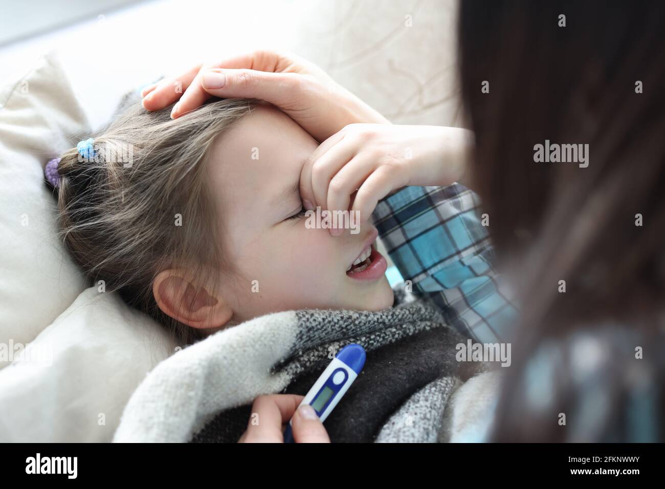 Mom measuring temperature of sick little girl with thermometer Stock ...