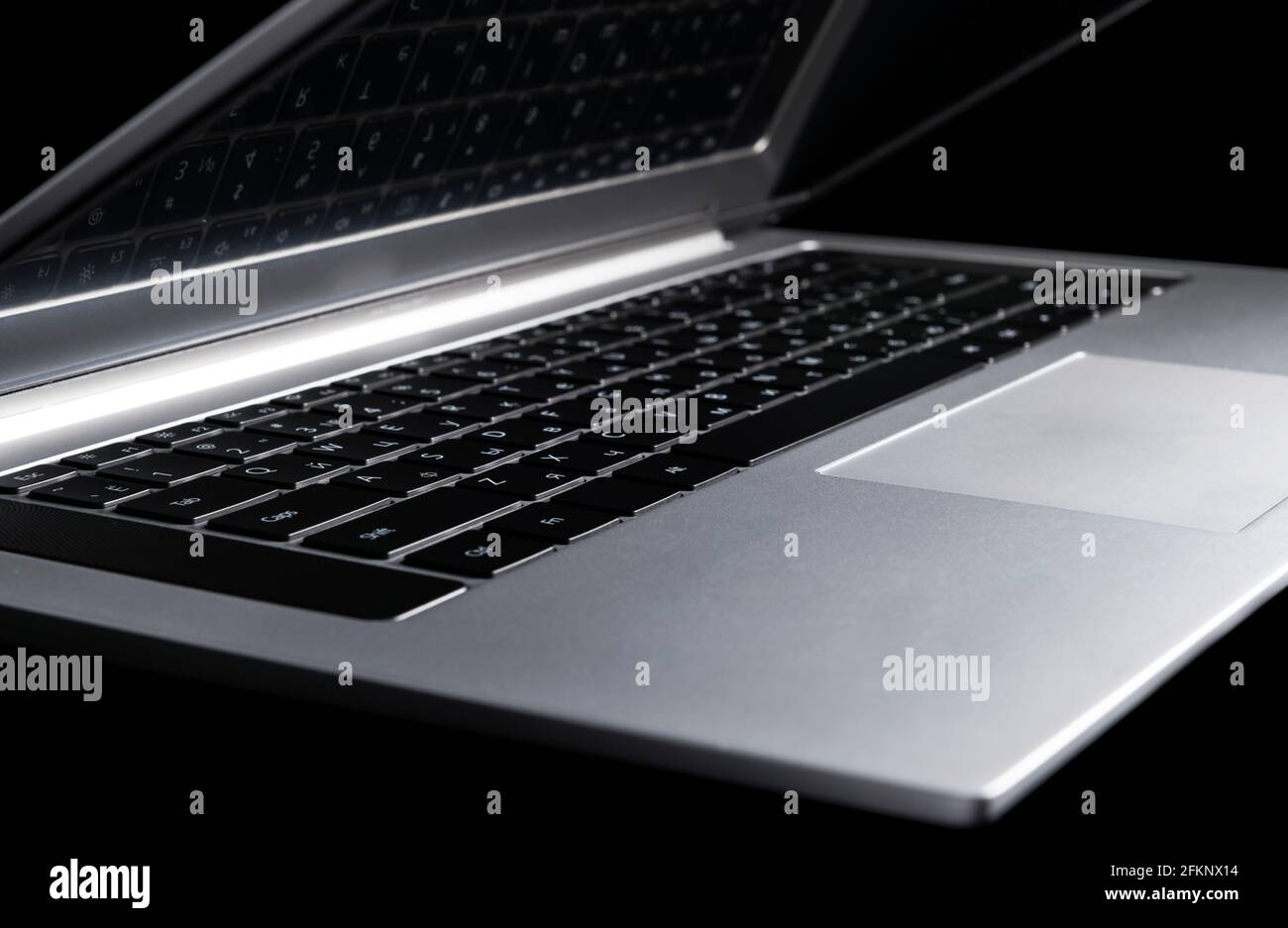 Silver Laptop and keyboard against a black background. Laptop keyboard ...
