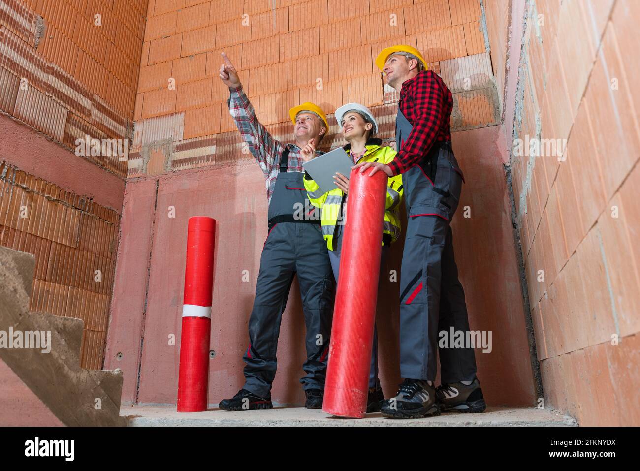 Male construction workers discussing project of building Stock Photo ...