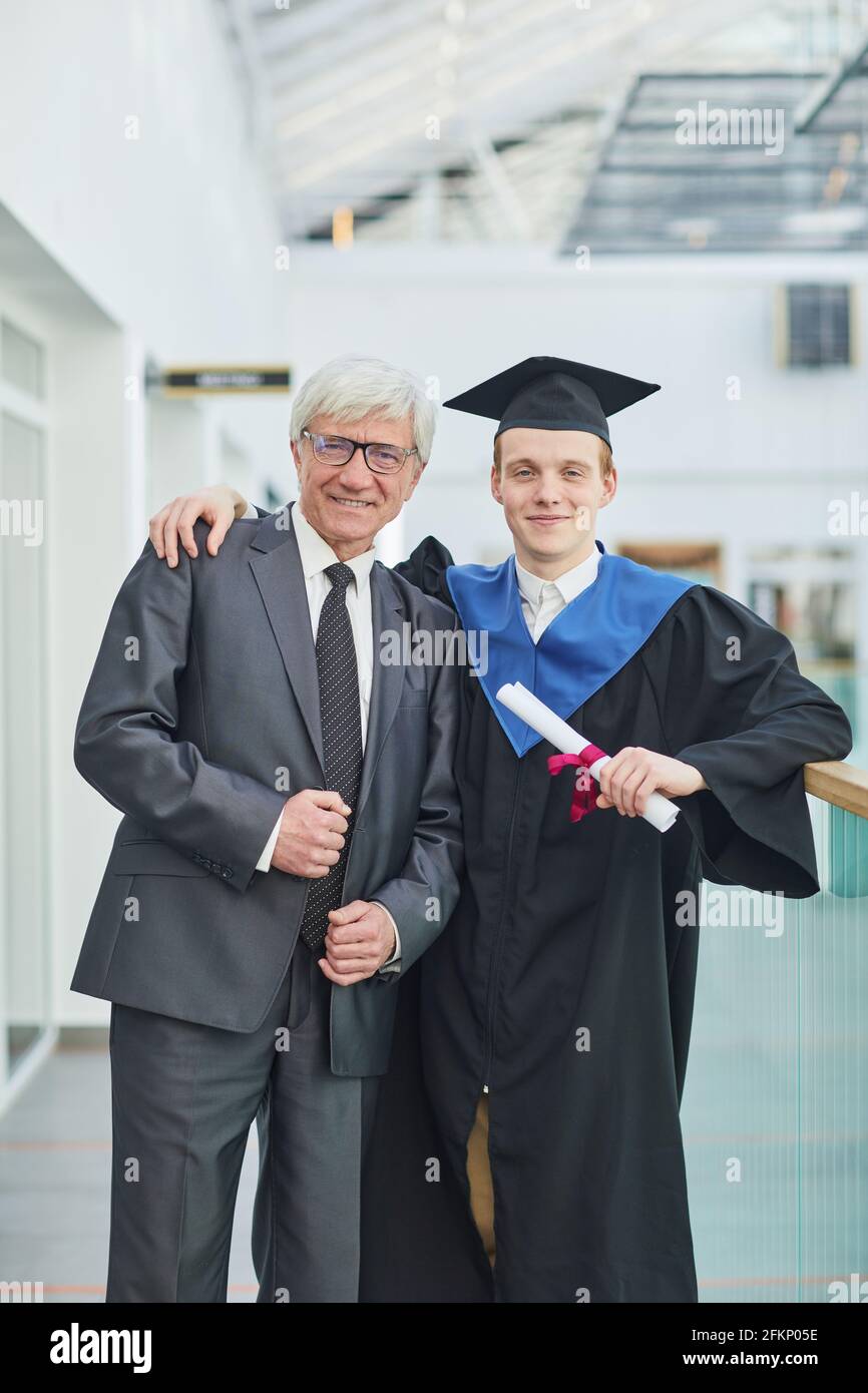 Vertical portrait of smiling young man posing with father during ...