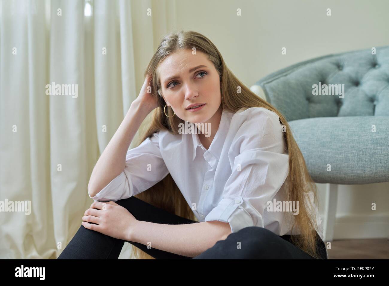 Upset crying young woman sitting at home on the floor Stock Photo - Alamy