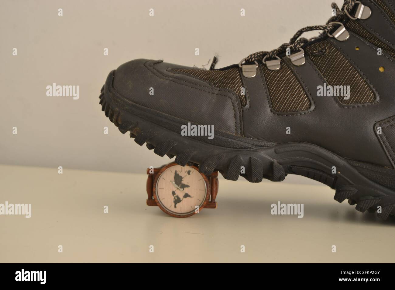 Security Boot. Leather safety boot stepping on wooden analog clock with ...