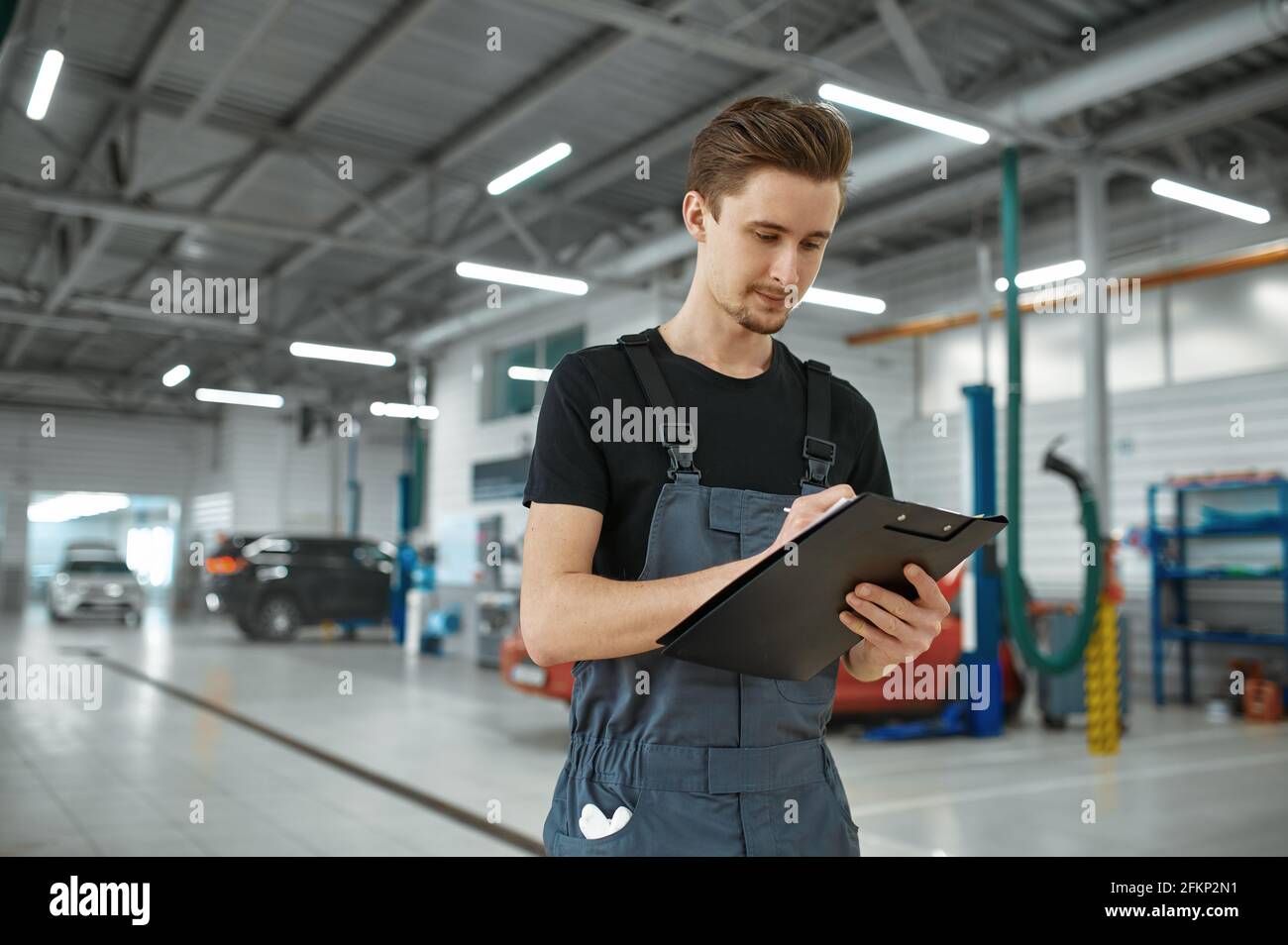 Male mechanic with checklist, car service Stock Photo - Alamy