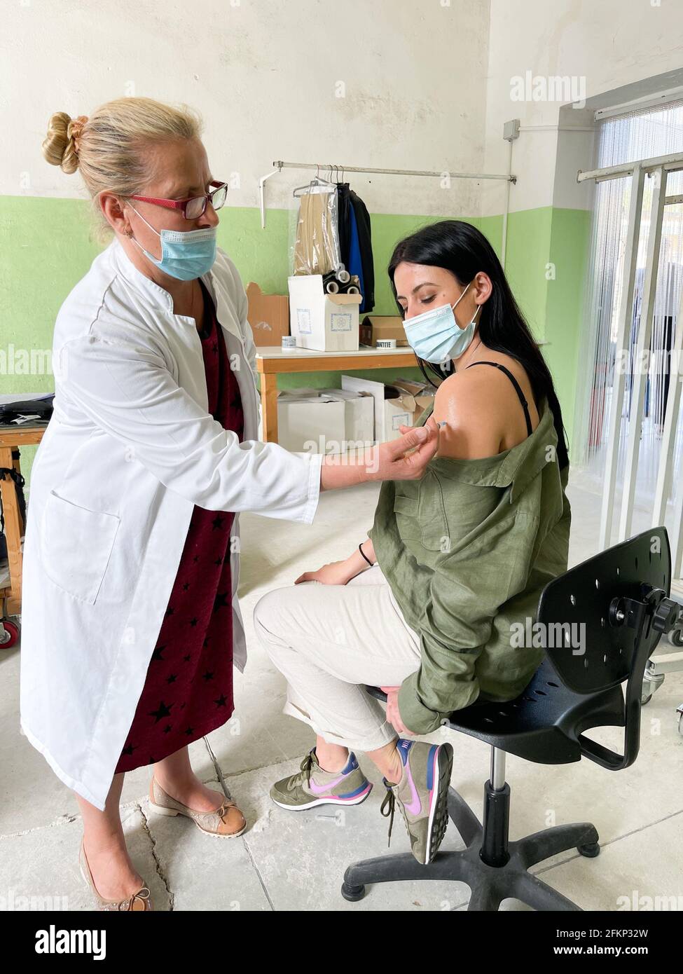 Woman receiving an injection in her arm Stock Photo - Alamy