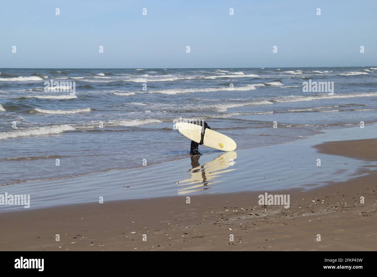 Person holding a surfboard on the Lokken beach, Denmark Stock Photo - Alamy